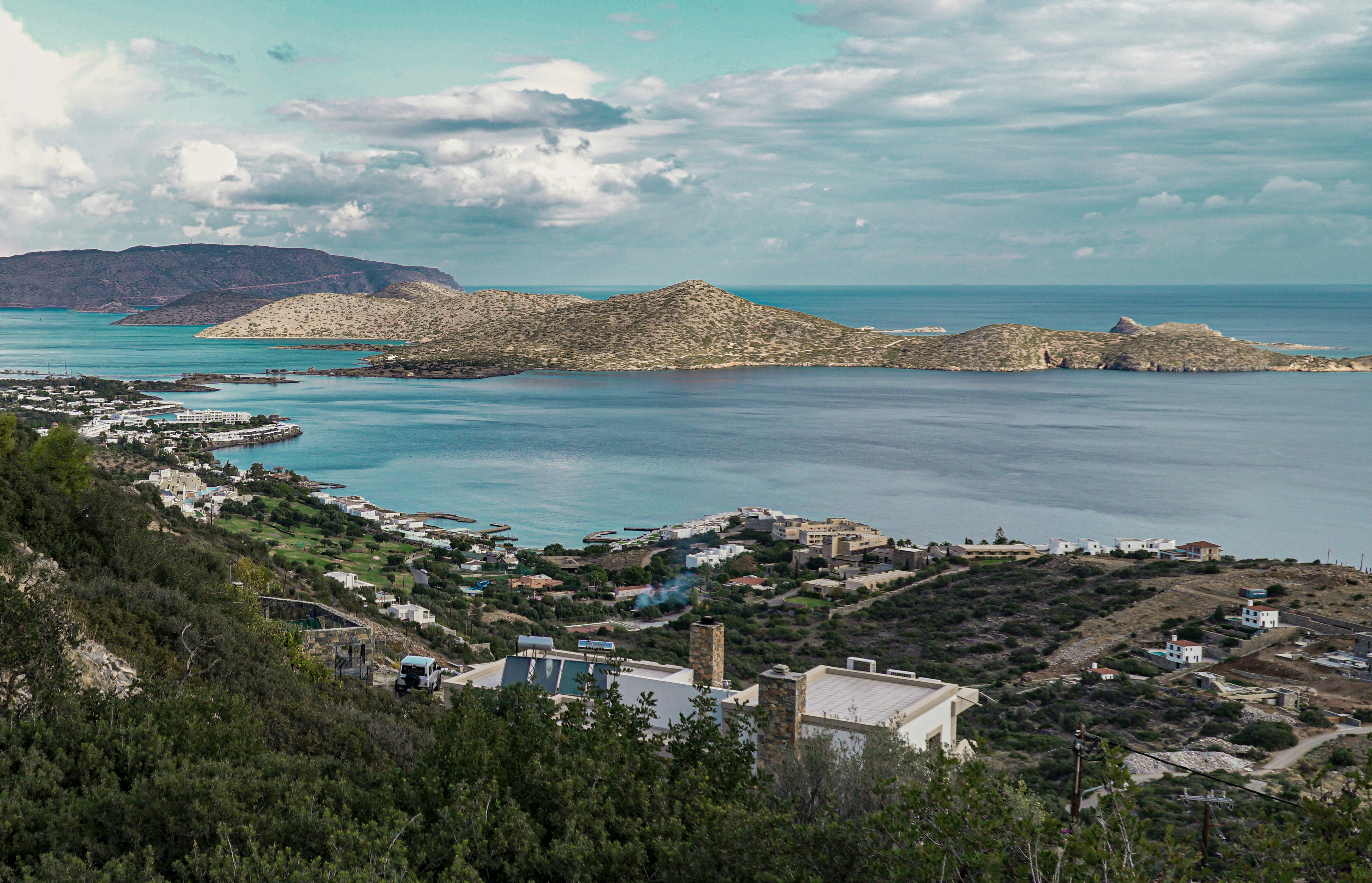 Terraced Horizon: A hillside village framed by a sapphire bay and distant islets