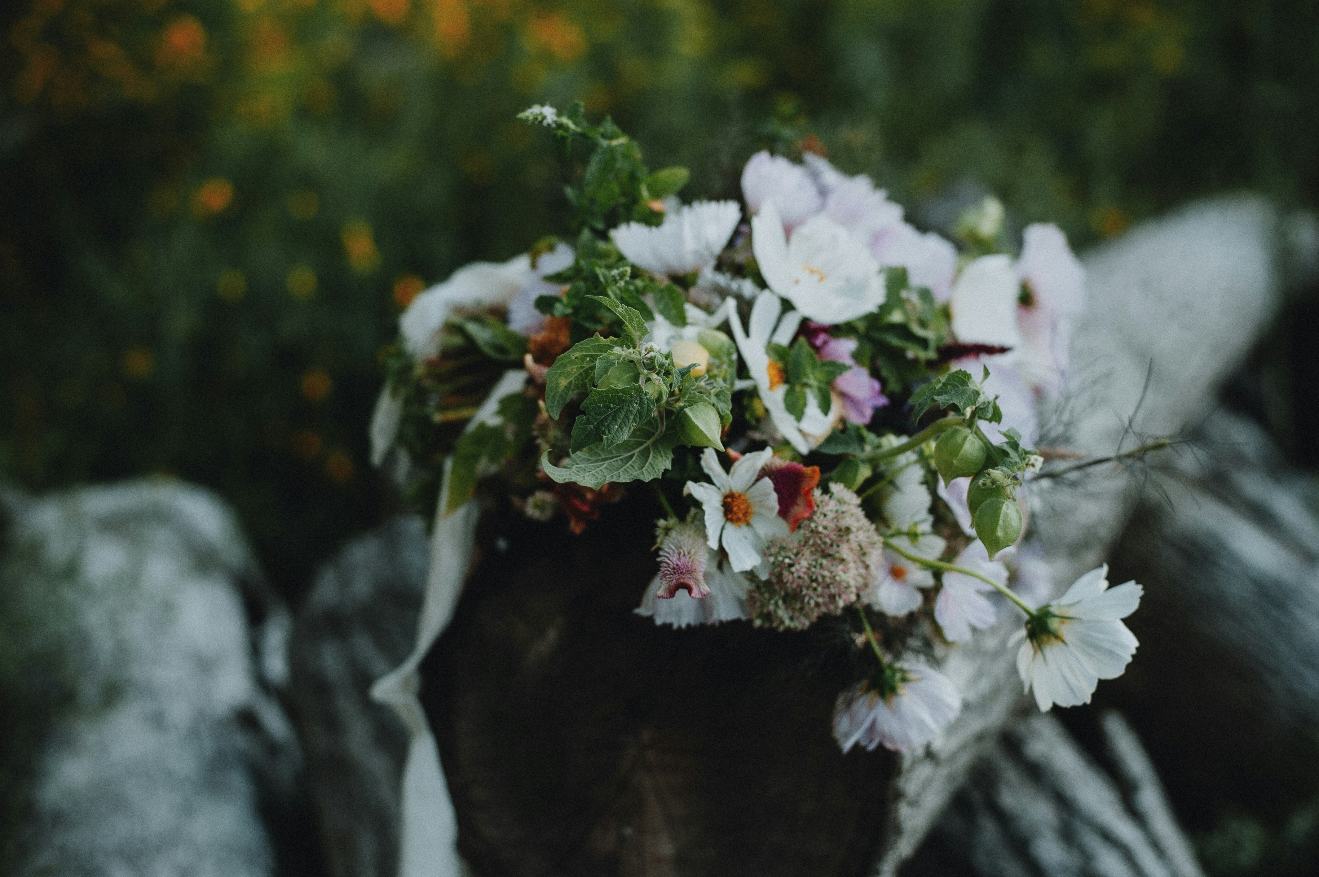 a bouquet of flowers sitting on top of a rock