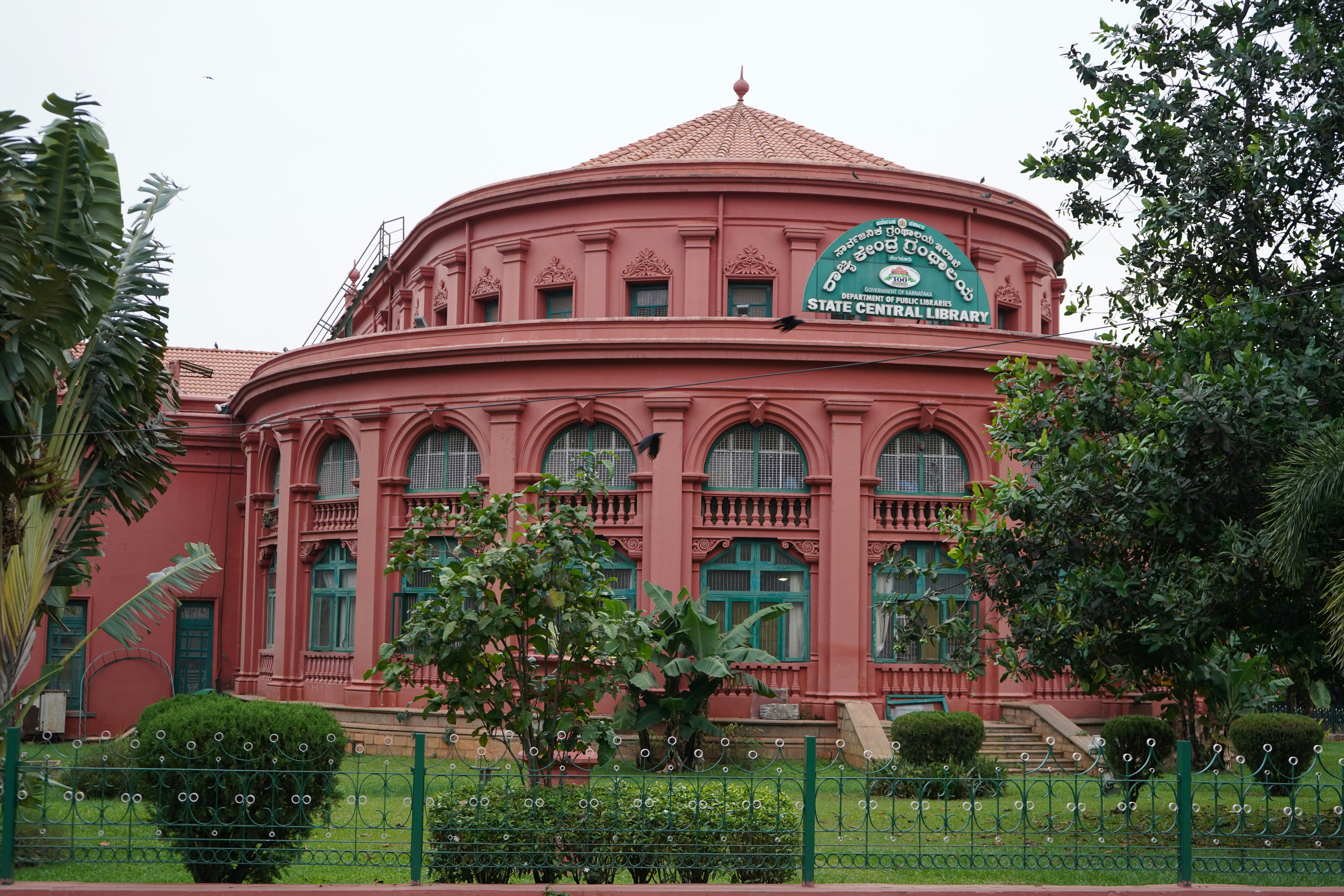 A red building with a green fence around it photo – Free State central ...