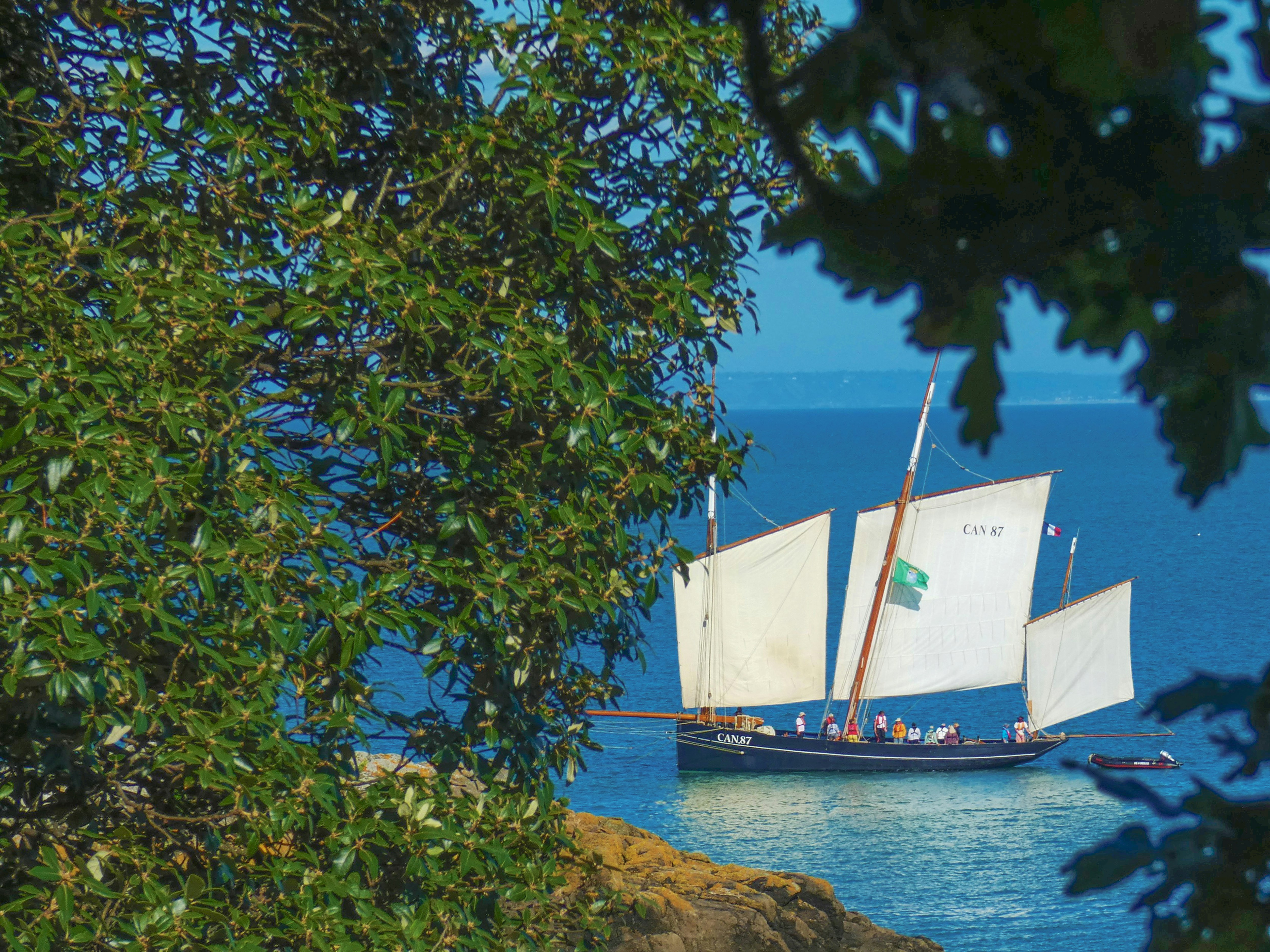 A sailboat sailing on the ocean near a cliff photo – Free France Image ...