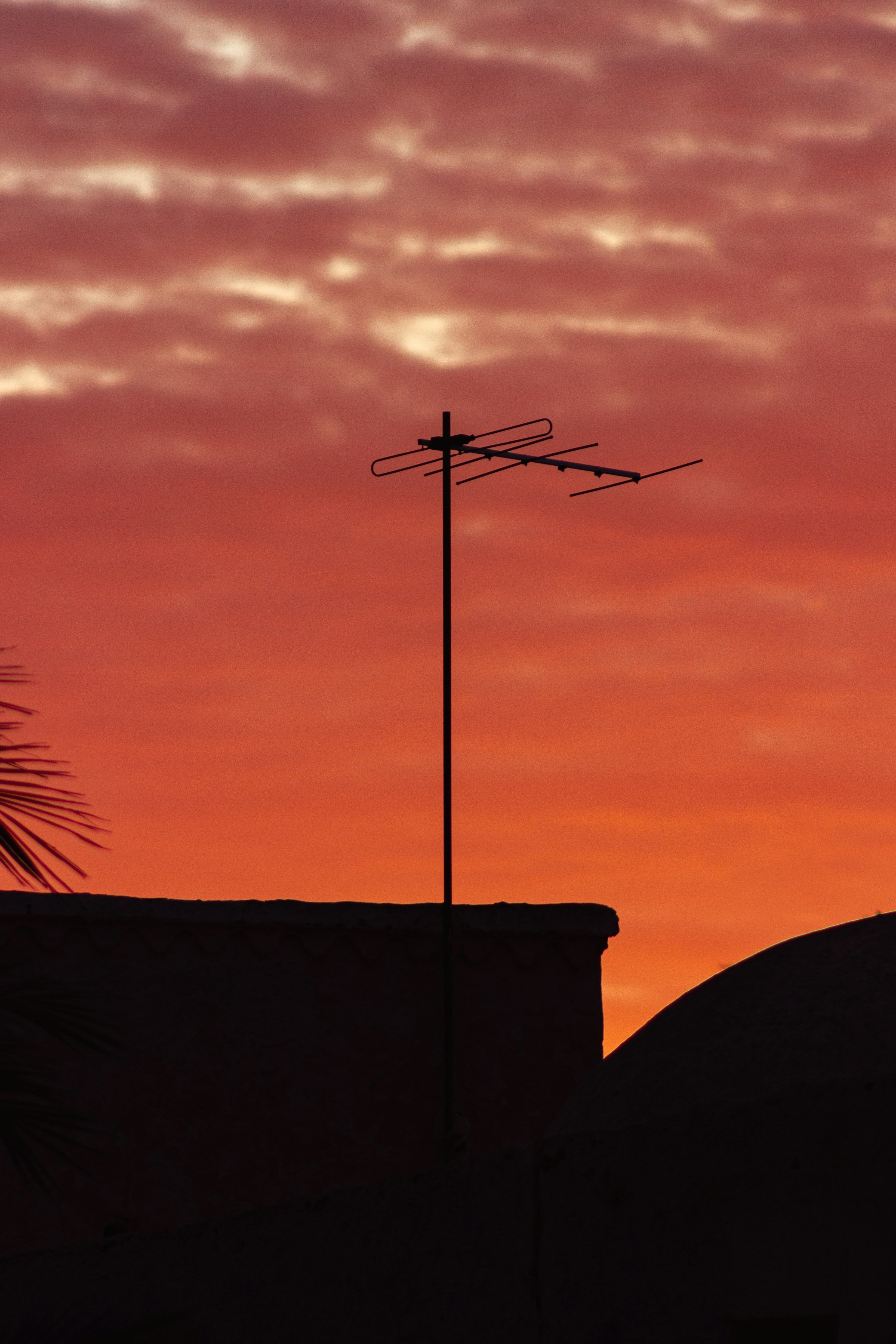 Rooftop Antenna at Dusk: A Fiery Skyline Silhouette