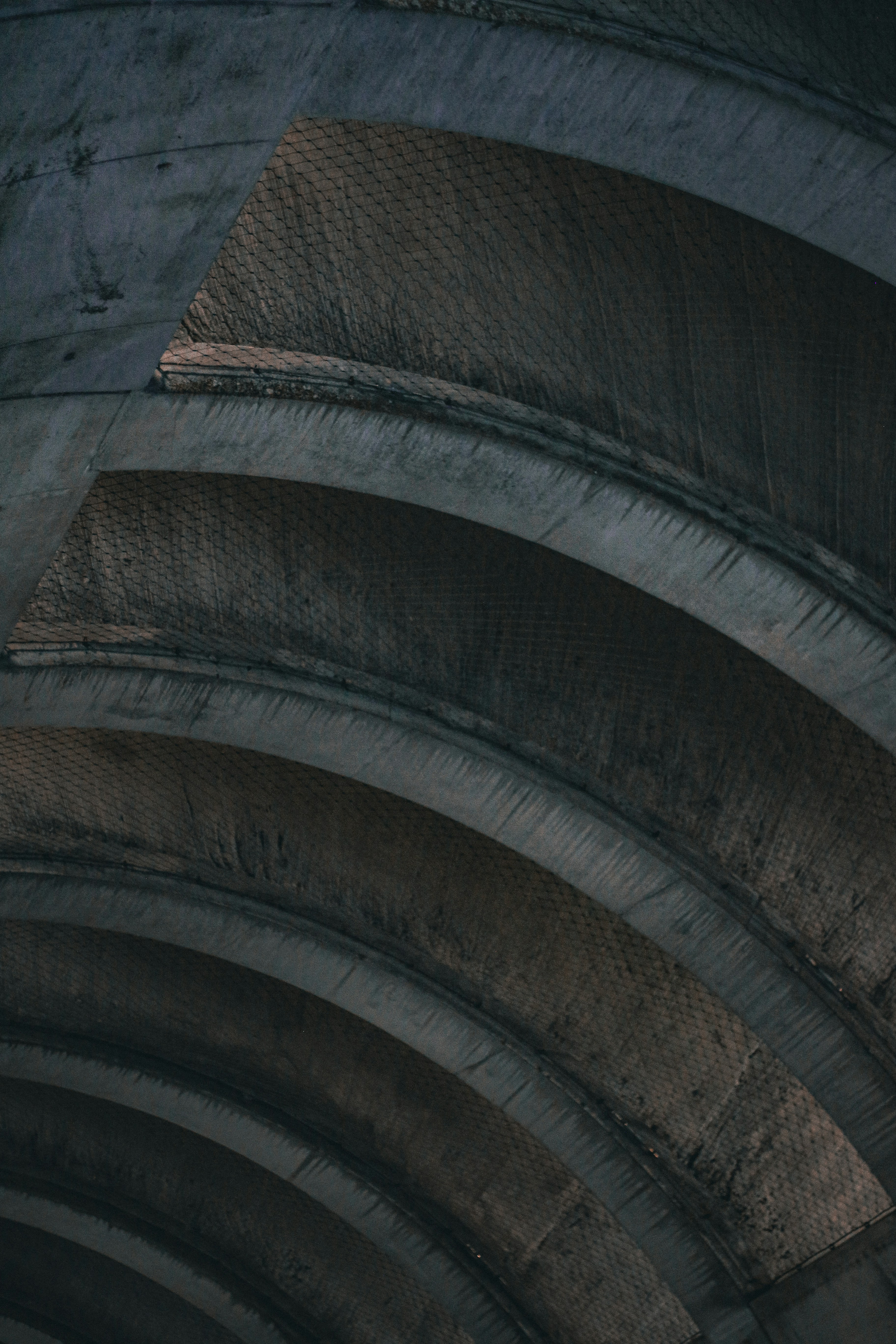 A brutalist parking photographied from above. | a clock on the side of a building