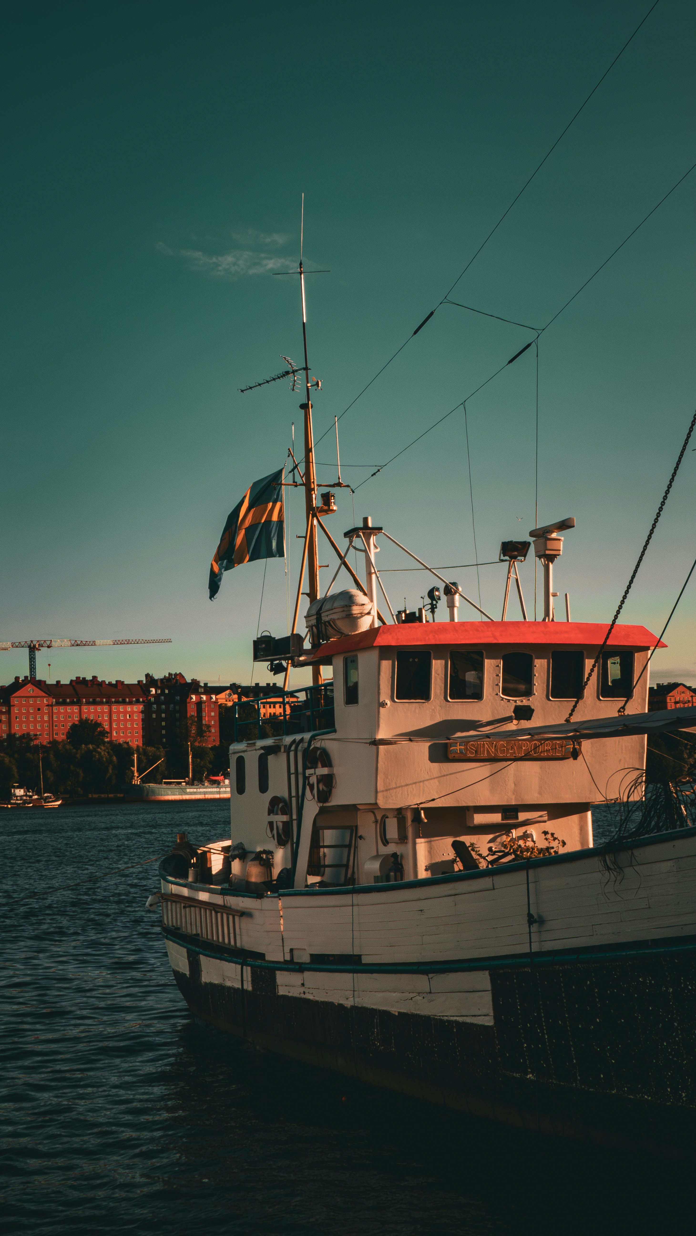 Dusk Vessel: A Red-Cabined Harbor Boat Against a Teal Sky