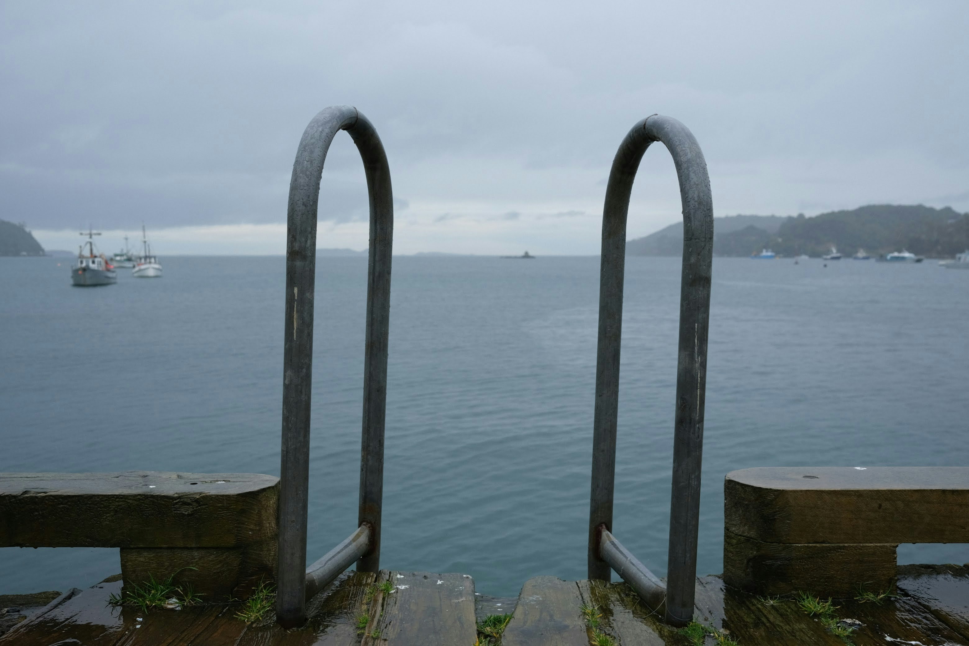 A wooden dock with two metal bars on it photo – Free Stewart island ...