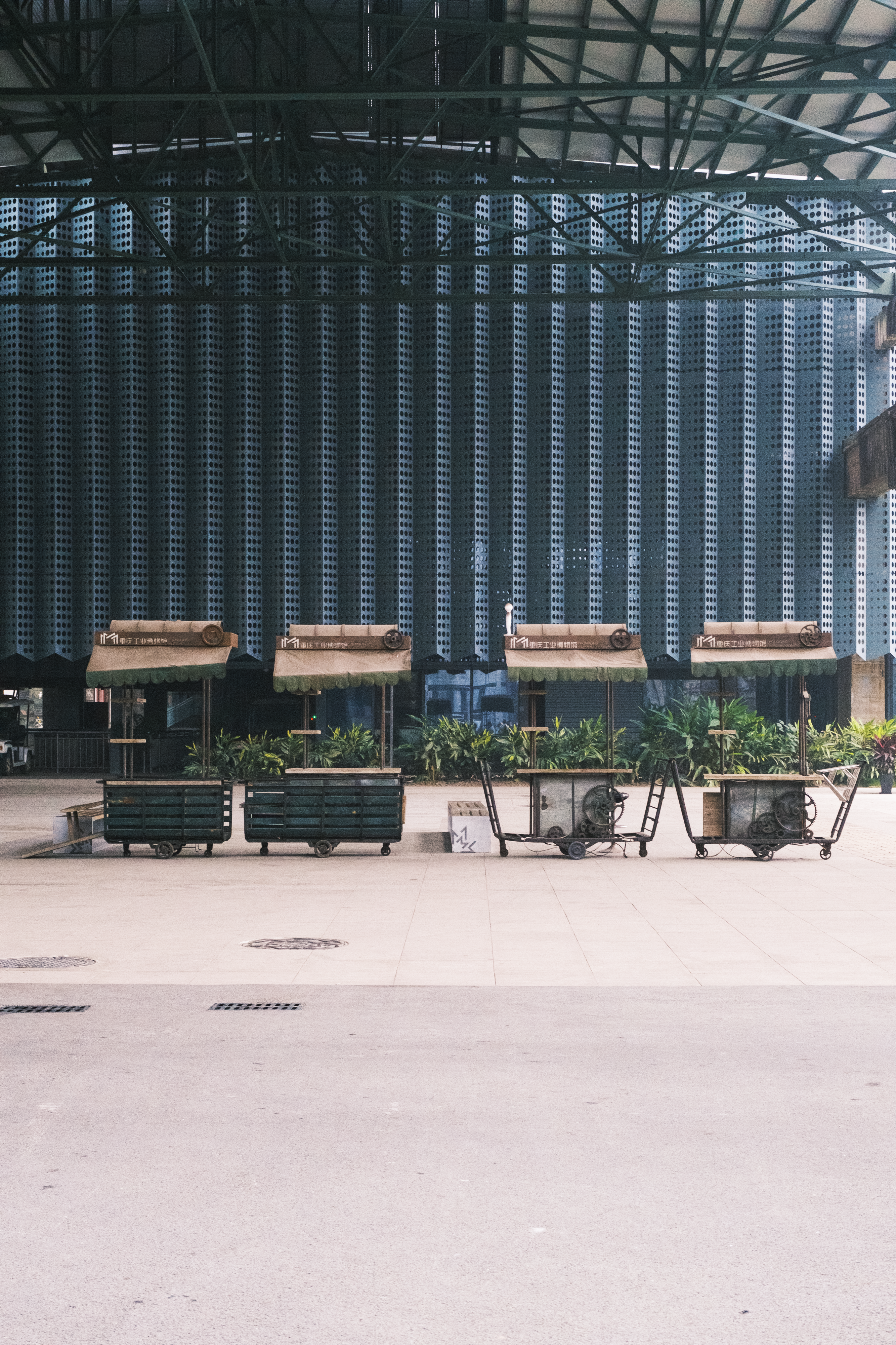 Shaded market stalls beneath a lattice of steel and glass