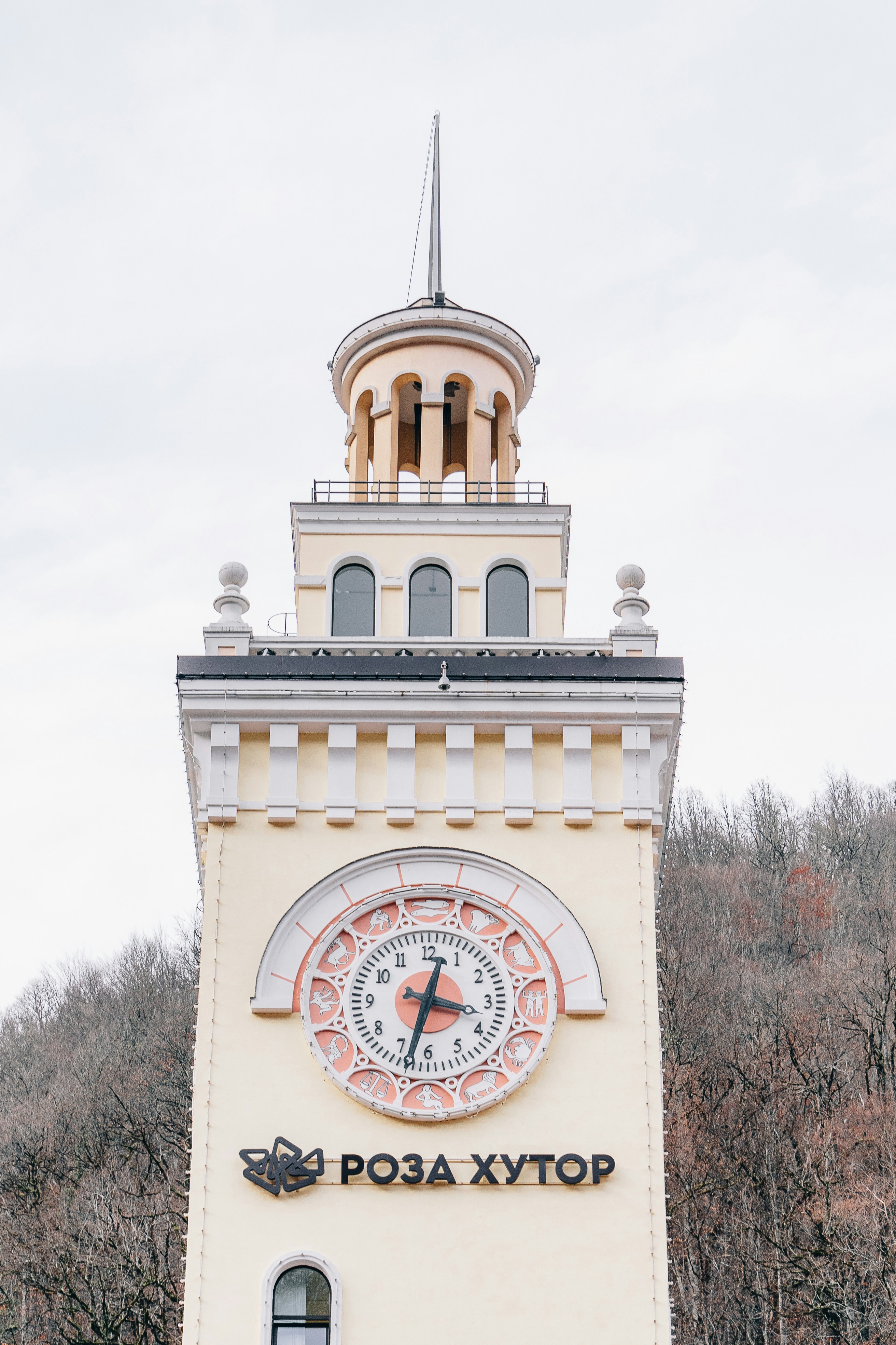 Rosa Khutor Clock Tower: Pale Winter Beacon Above Bare Pines