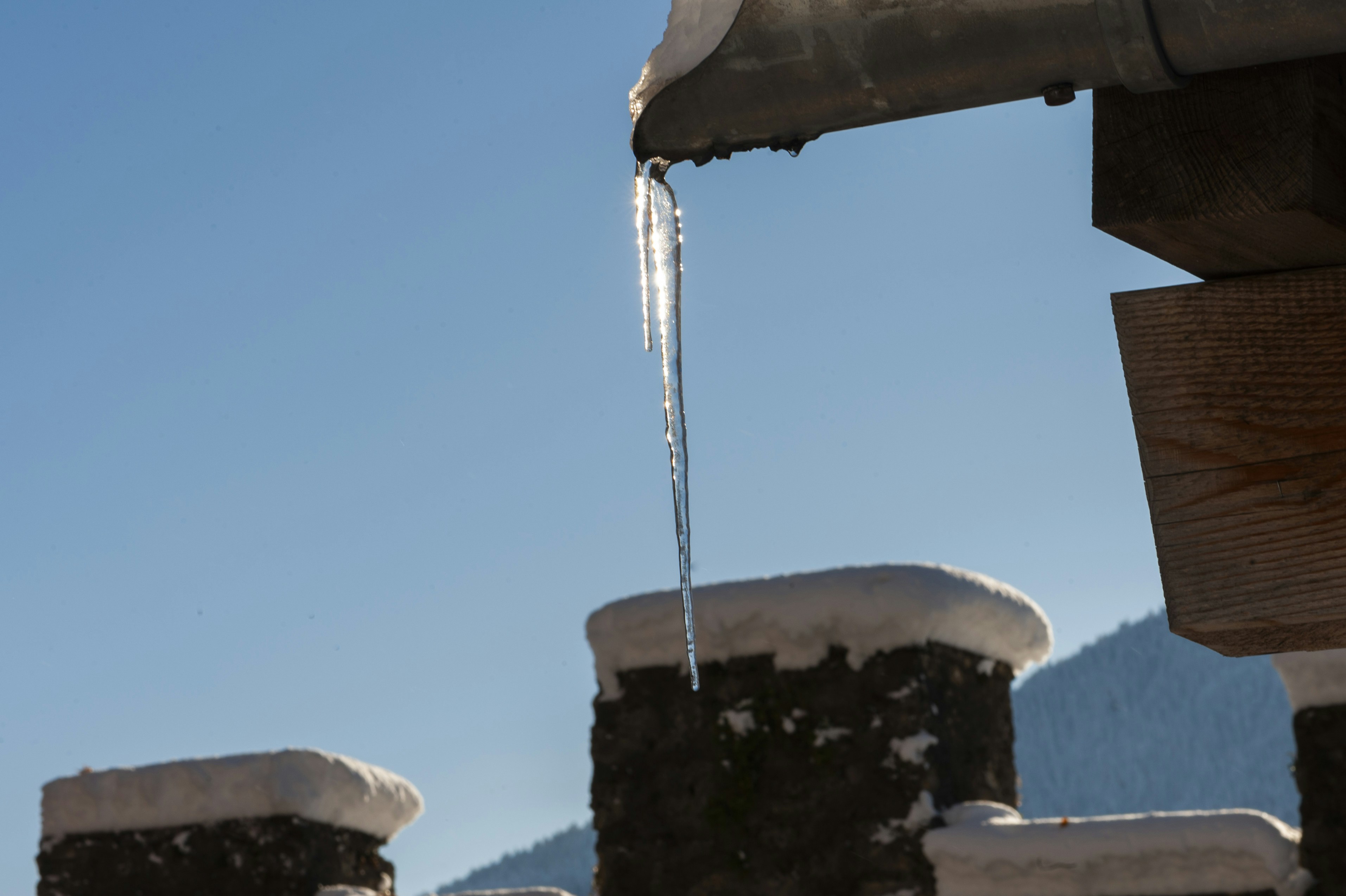A water spouting out of a pipe on top of a building photo – Free Blue ...