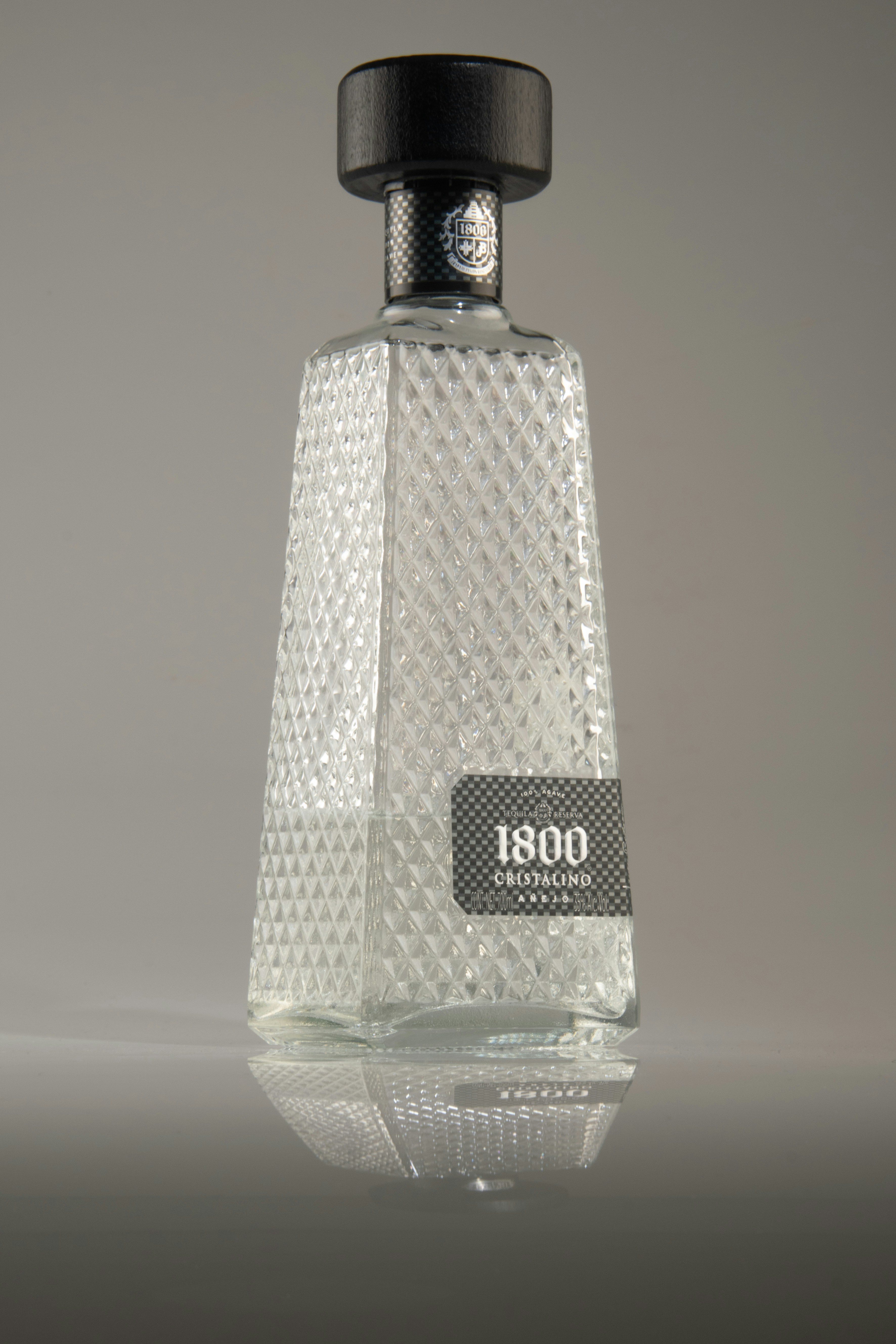 A glass bottle with a black top on a table photo – Free Grey Image on ...