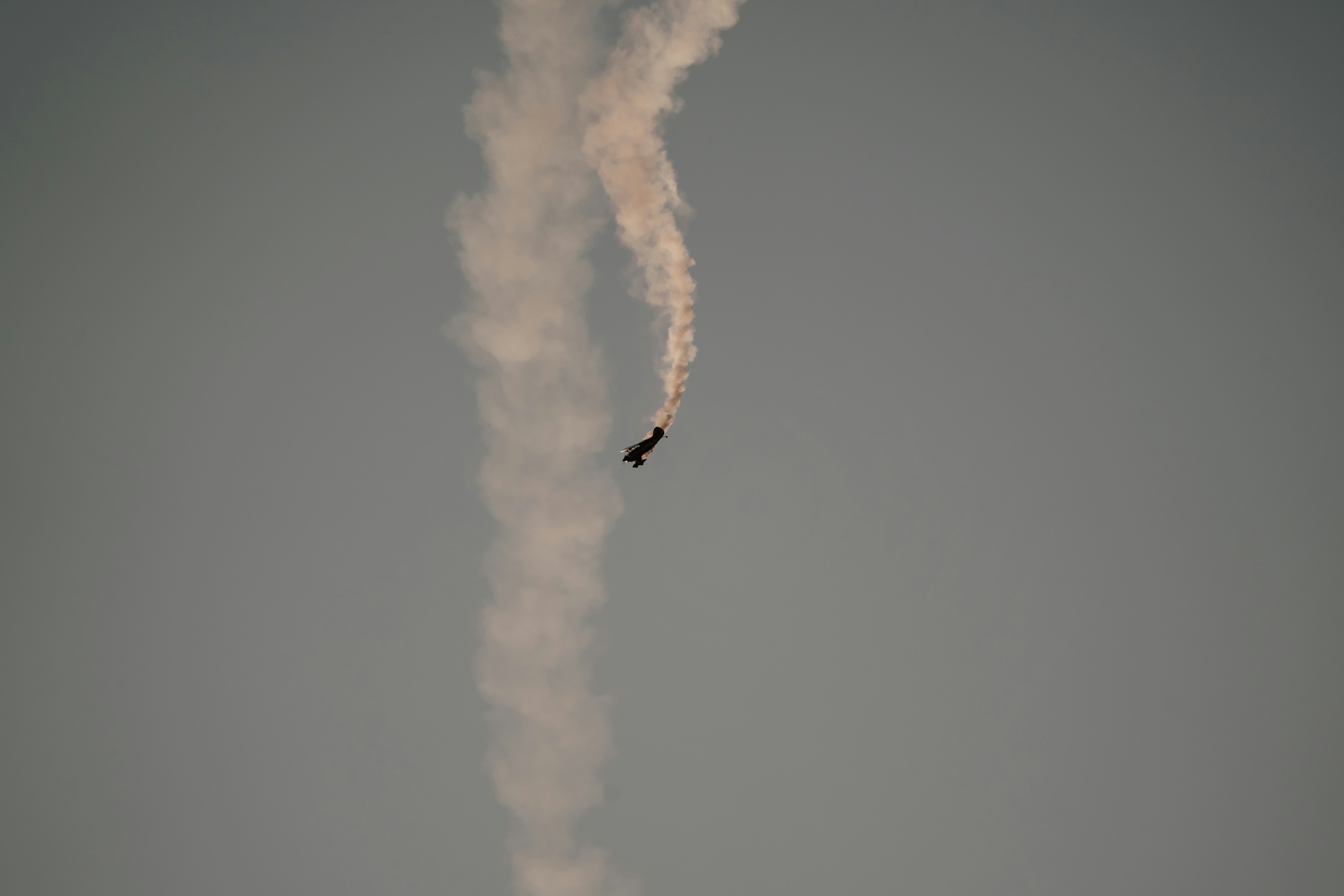 A small airplane flying in the sky with smoke coming out of it photo ...