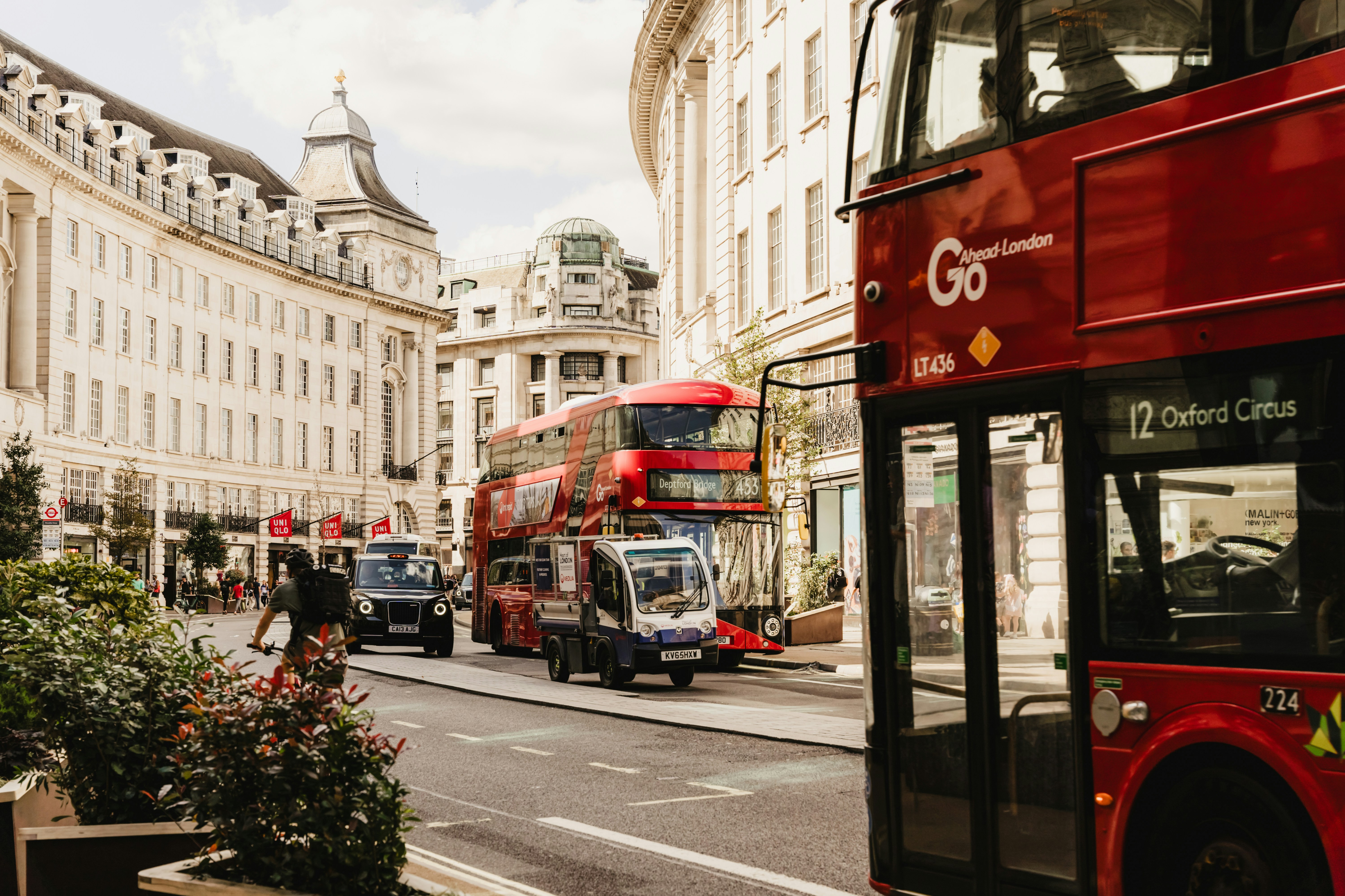 A red double decker bus driving down a street photo – Free Street ...