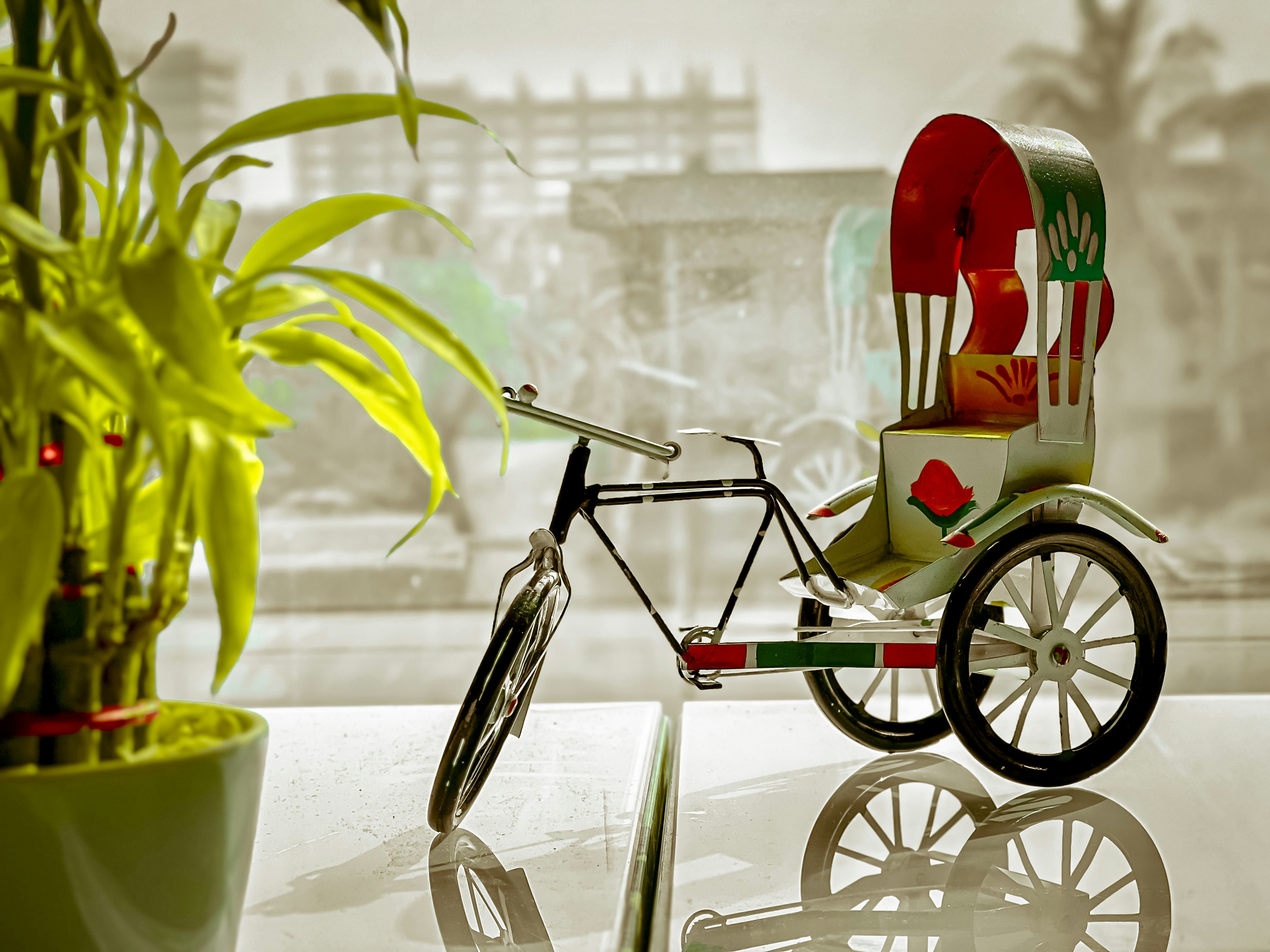 a toy bike with a basket on the back of it next to a potted