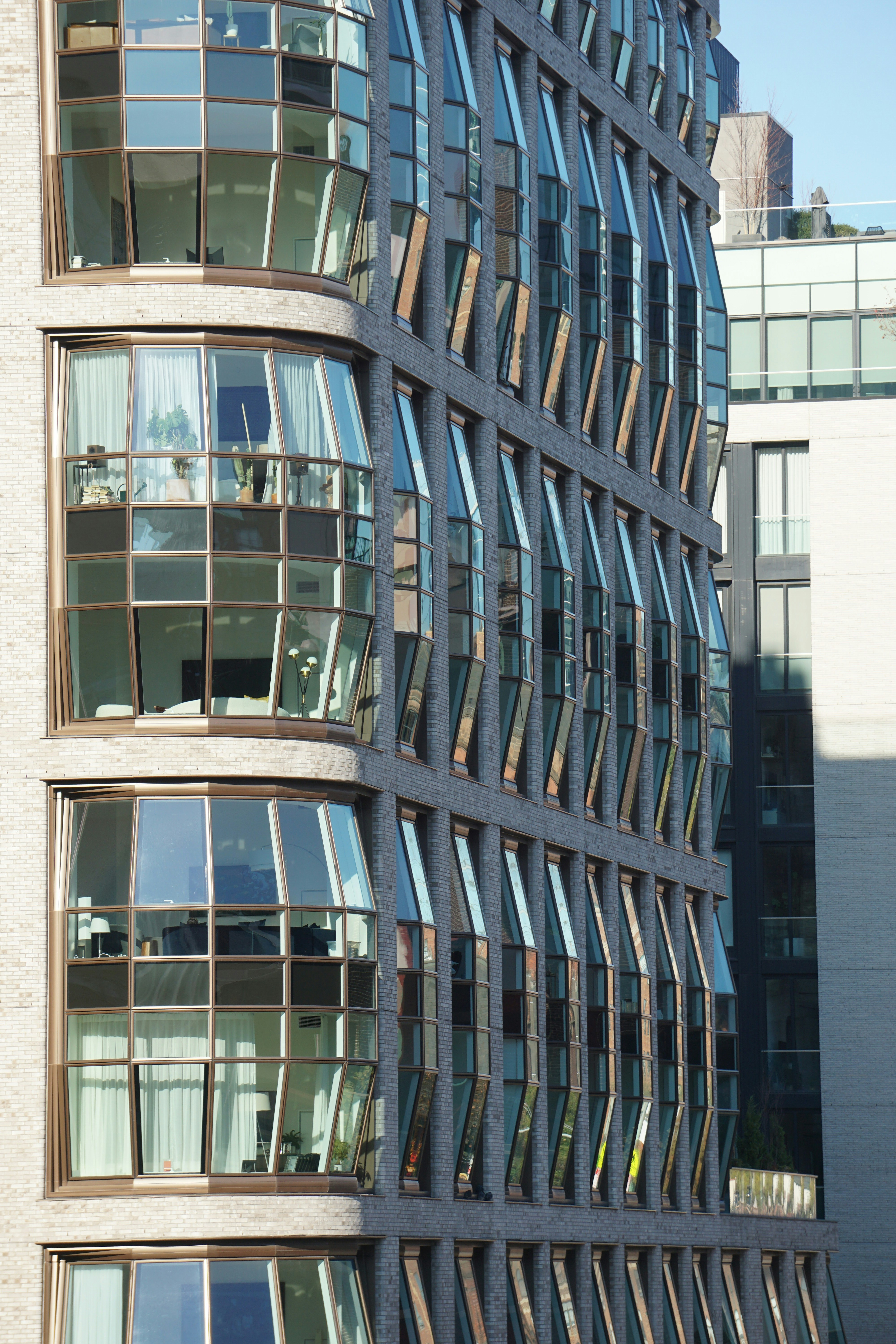 Angles in Glass: Repeating Bay Windows on a Brick Facade