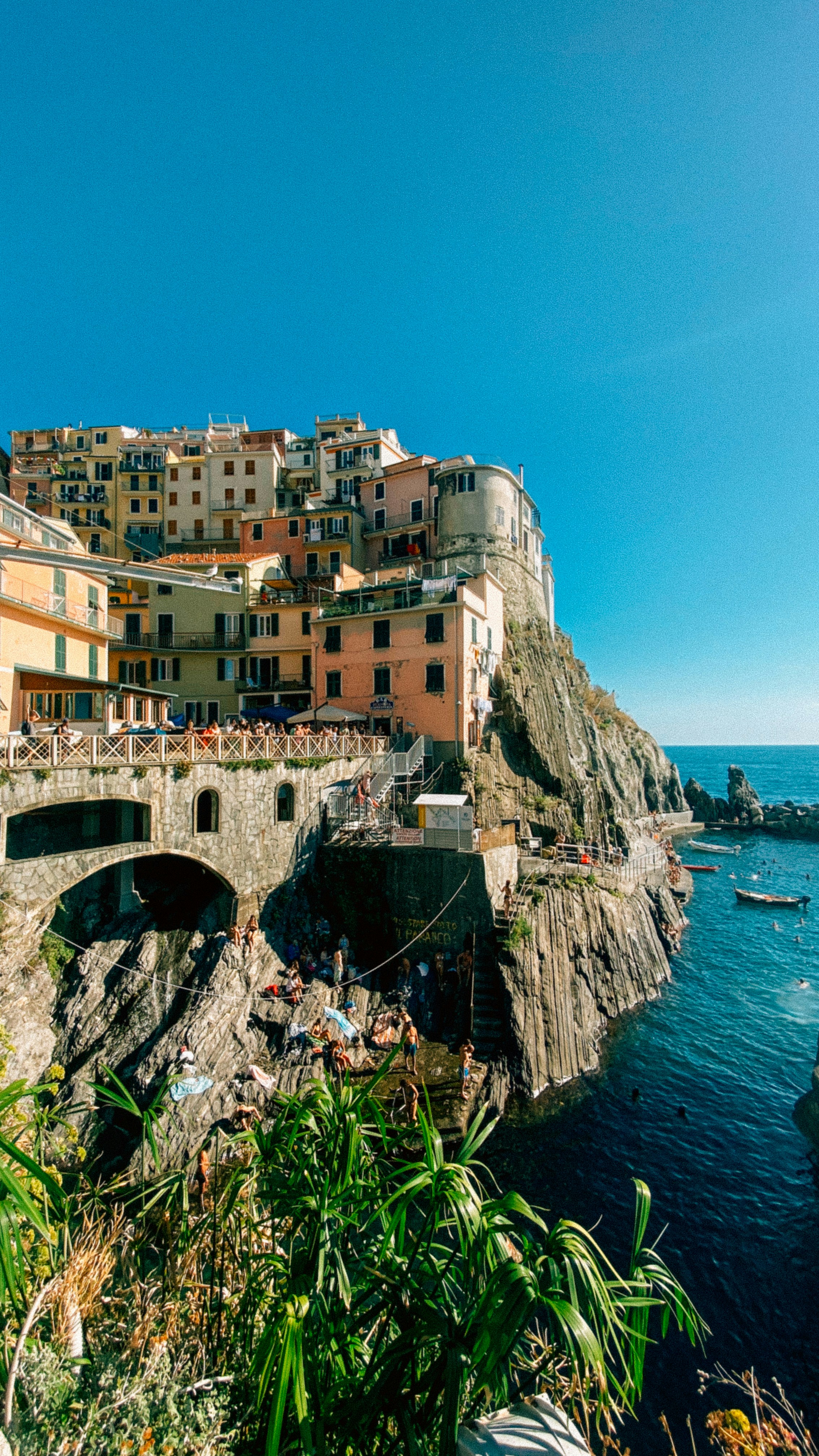 Colorful cliffside village curling into the sea under a clear blue sky