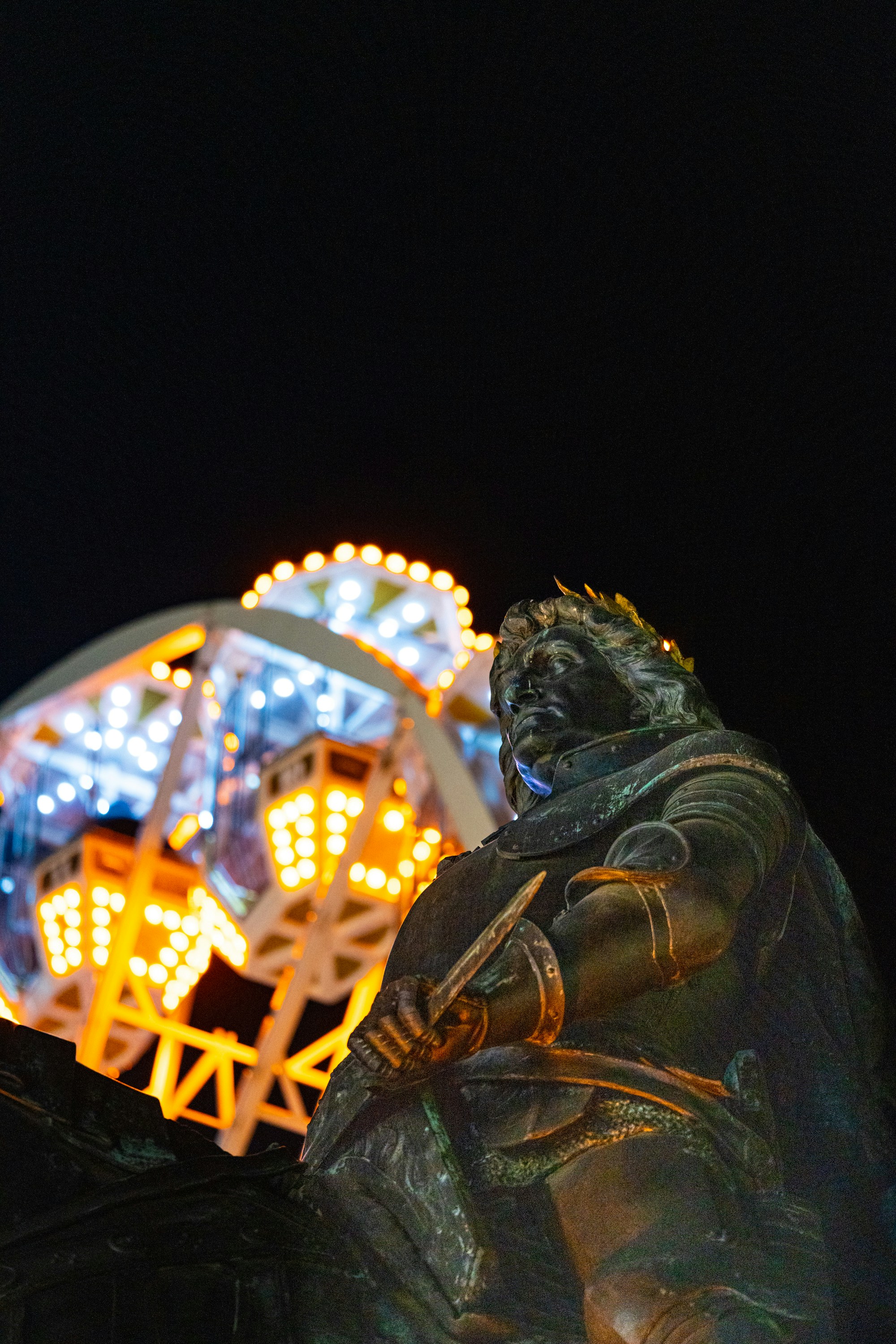 Night Sentinel: Bronze Warrior Framed by Neon Ferris Wheel