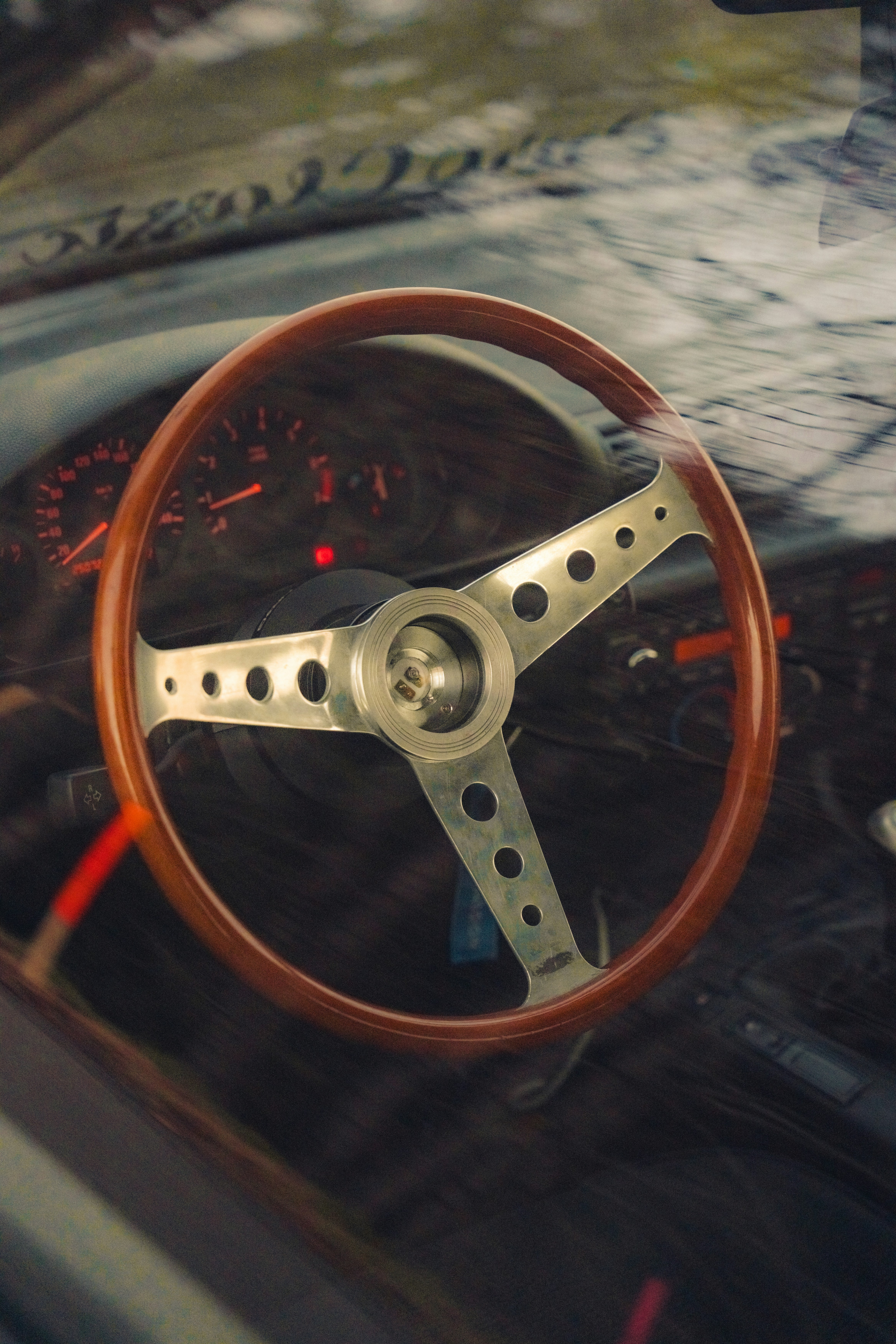 Echoes of Motion: a vintage wooden steering wheel framed by a blurred cockpit
