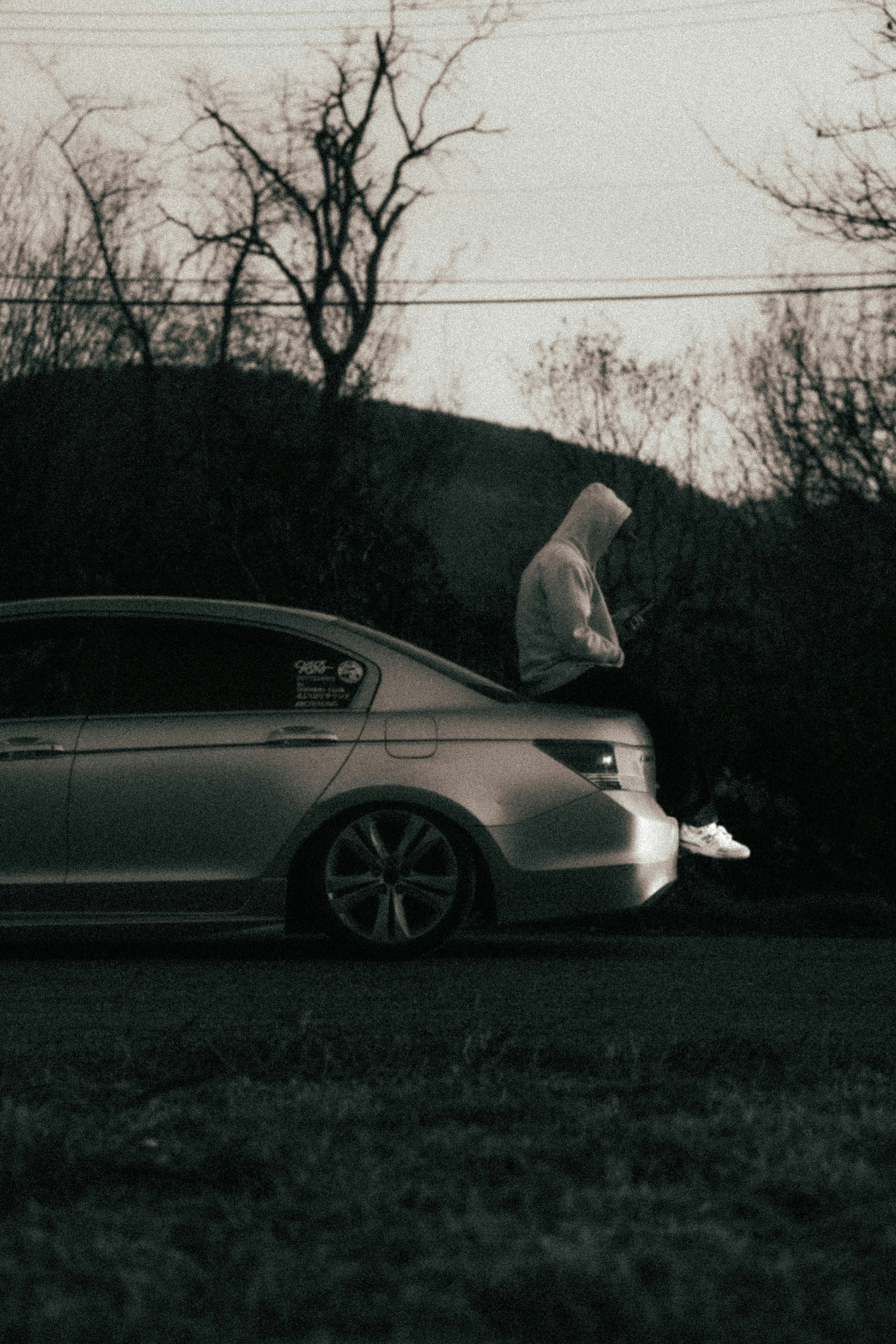 Midnight Confession: Hoodie Silhouette on a Paired-Down Sedan