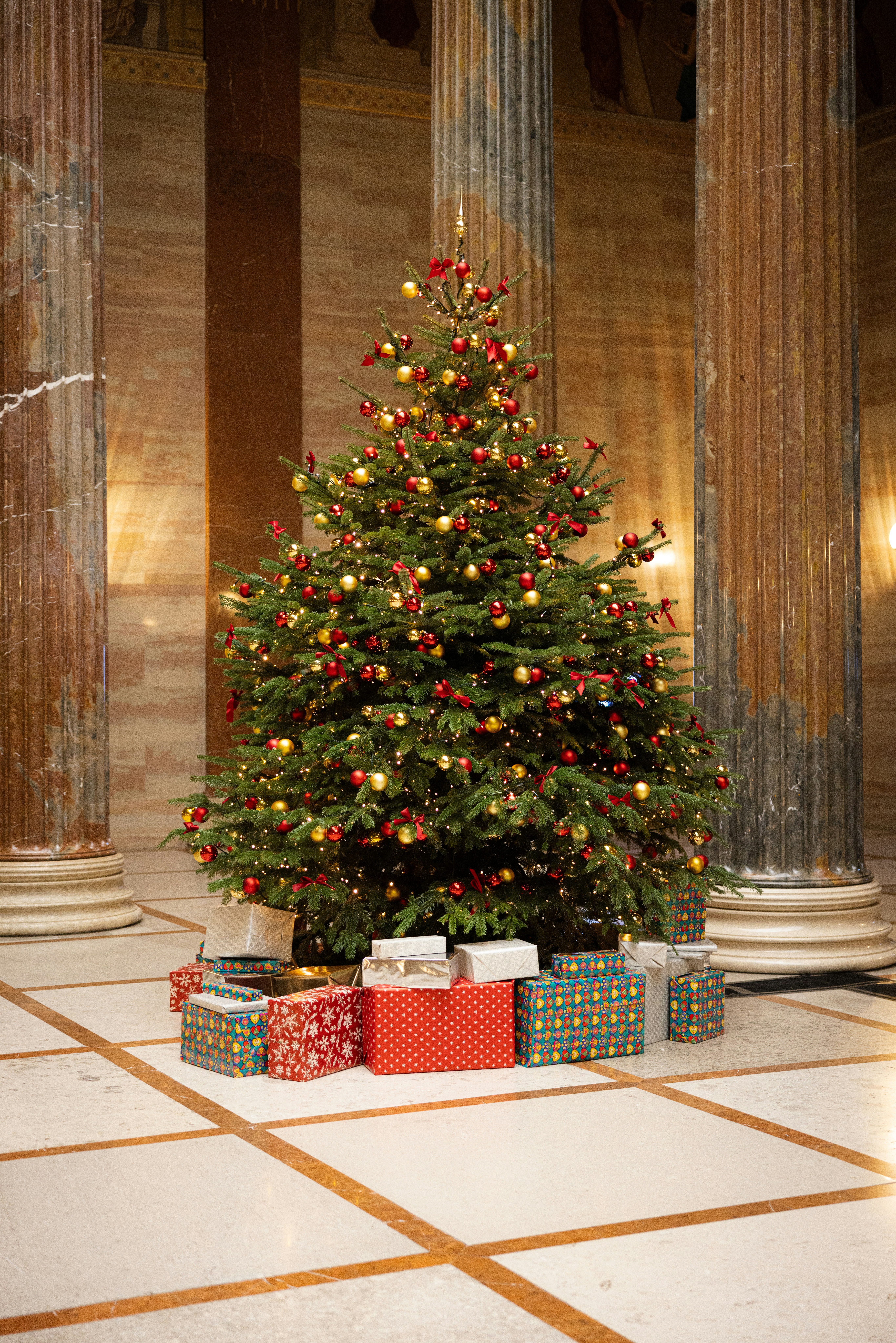 Yuletide Reverie in a Marble Atrium: Christmas Tree Surrounded by Wrapped Gifts