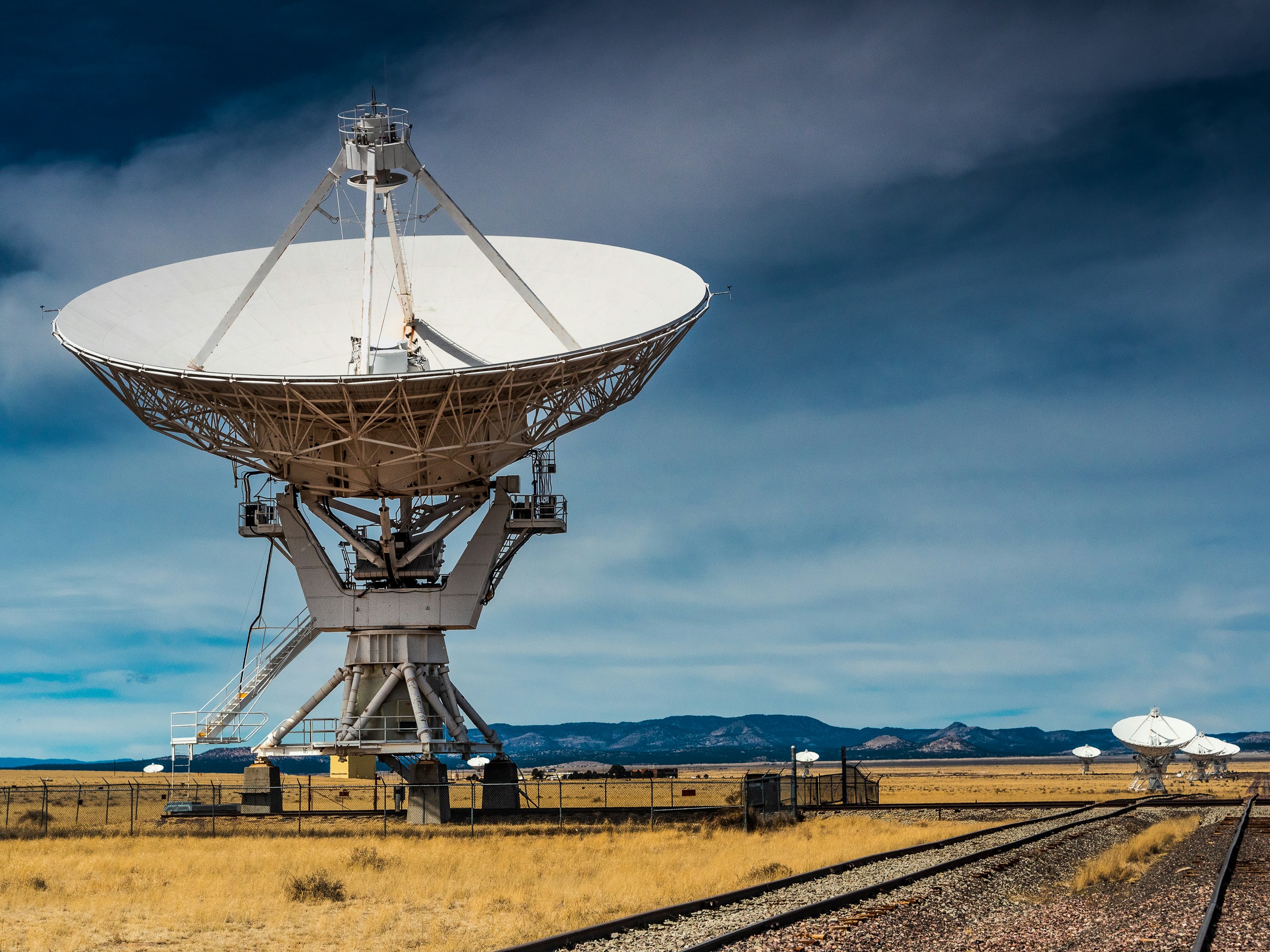 A very large satellite dish sitting on top of a train track photo ...
