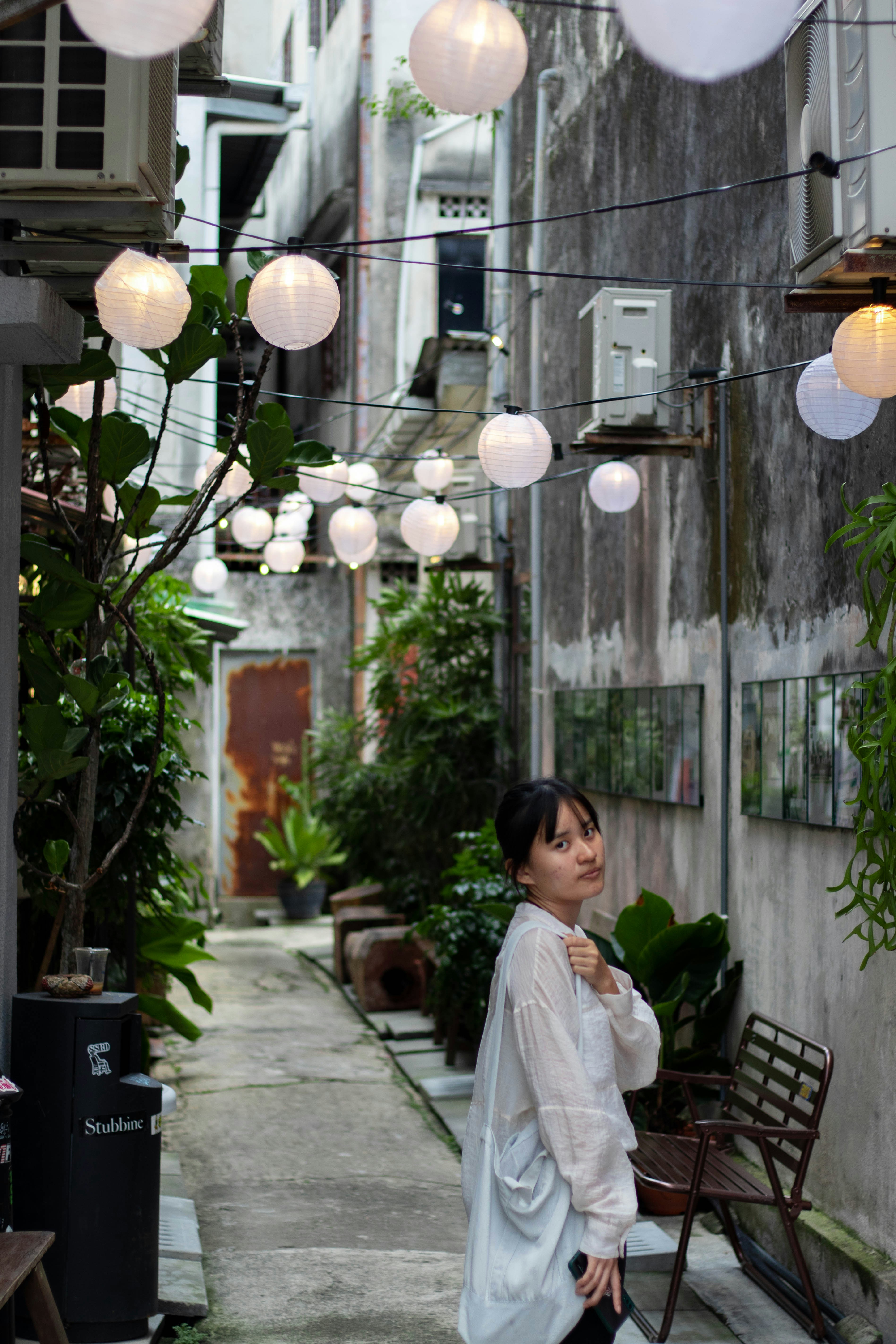 Lantern-Lined Alley Portrait Under a Sky of Orbs