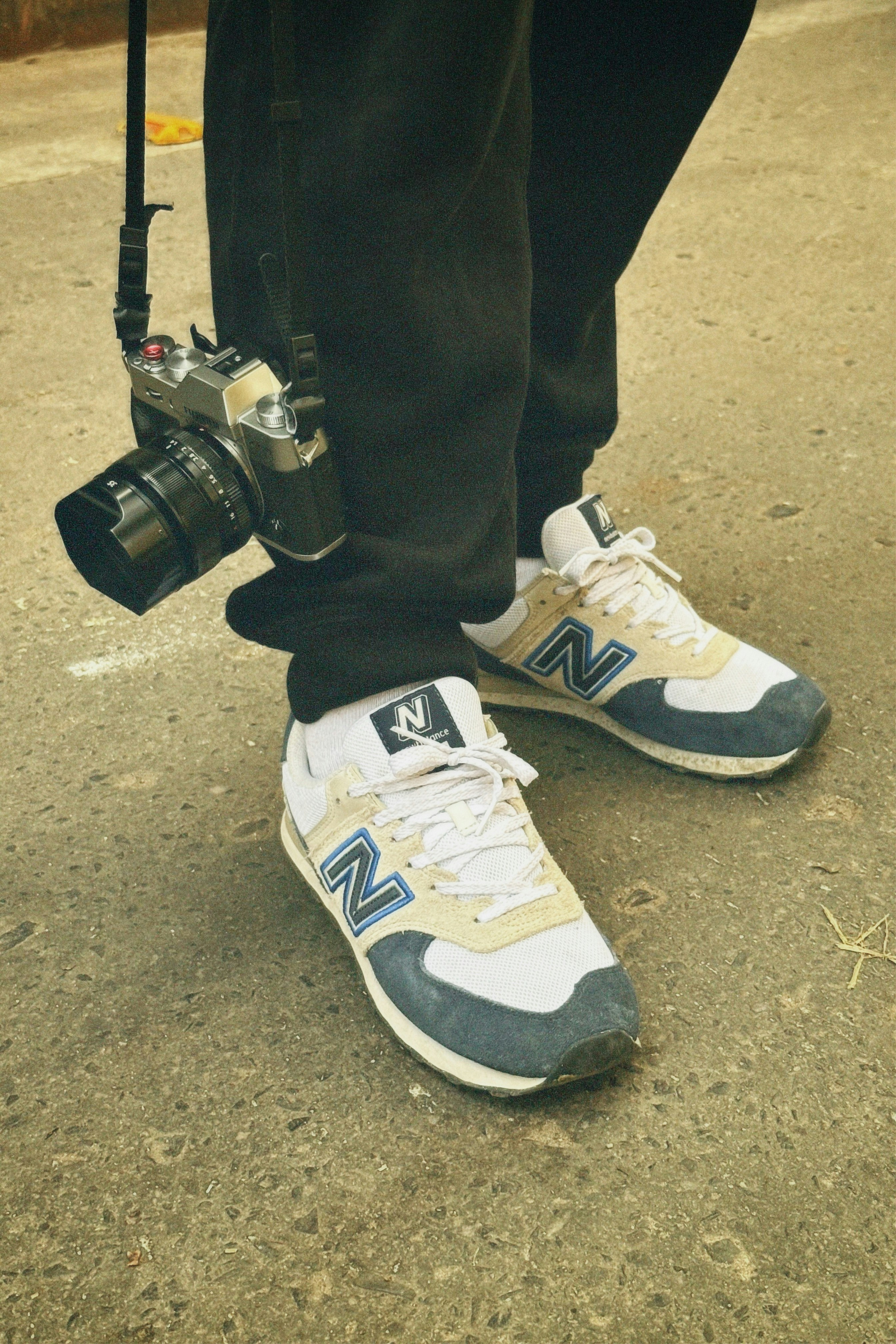 Vintage SLR on a Strap Paired with Cream and Navy New Balance Kicks