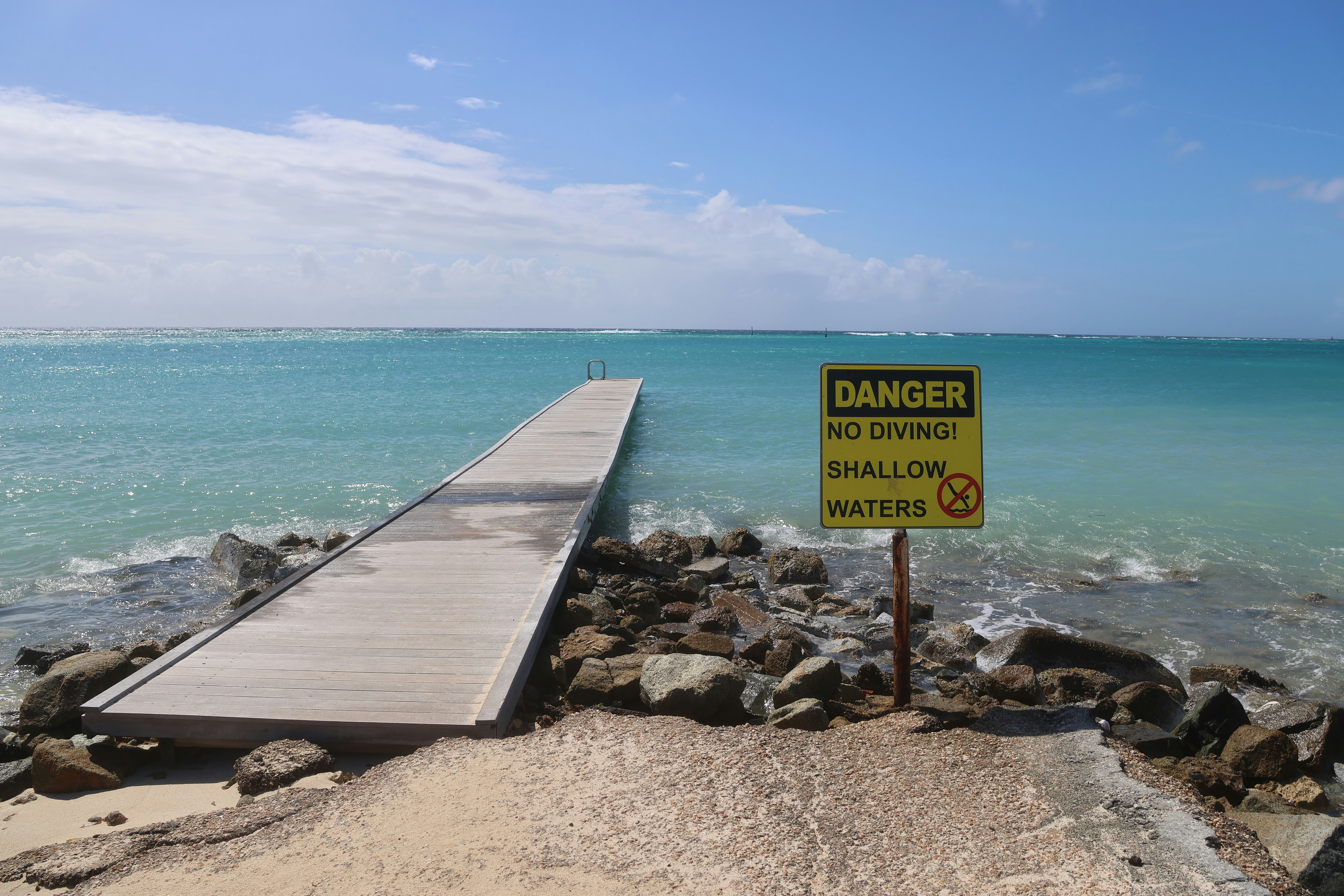 A sign warning of danger on a beach photo – Free Aruba Image on Unsplash