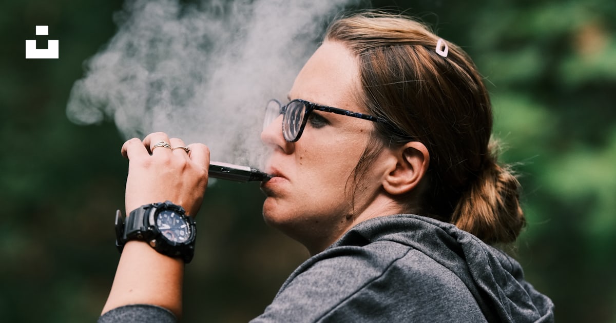 A Woman Sitting On A Rock Smoking A Cigarette Photo Free Praha 8