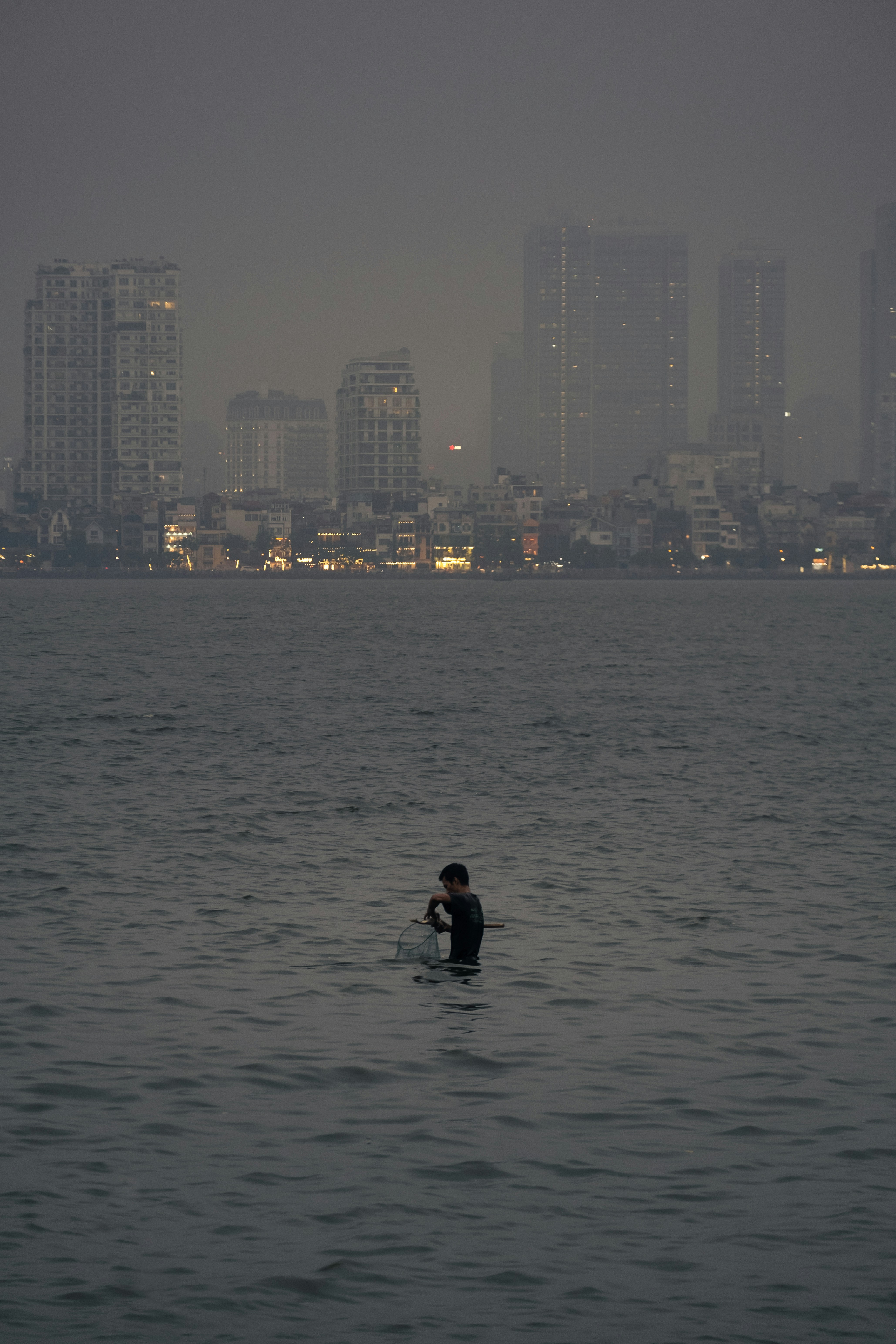 Harbor in Haze: A lone figure anchors the scene as the skyline fades