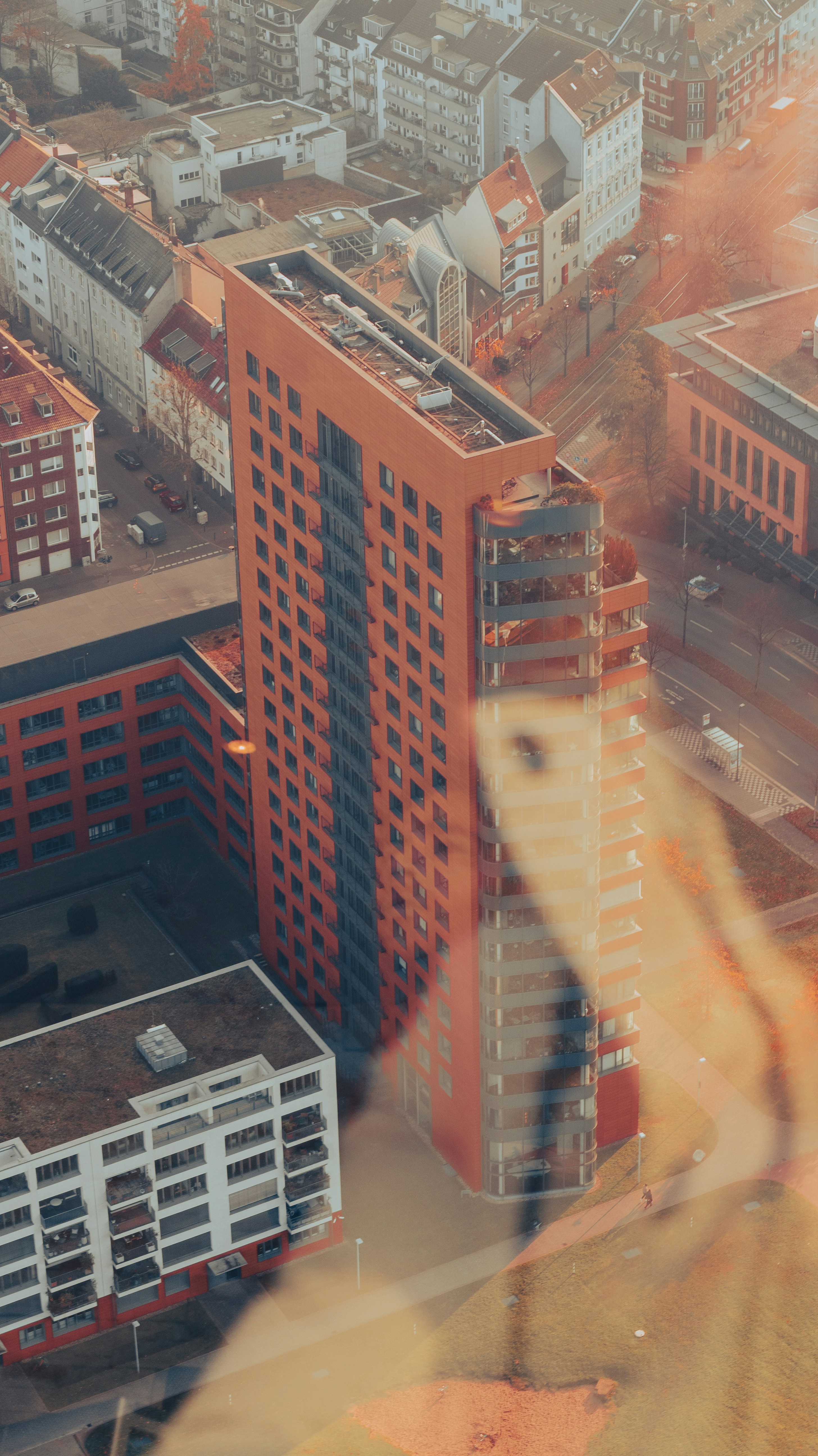 Crimson Spine Rising Over a Quiet City Block