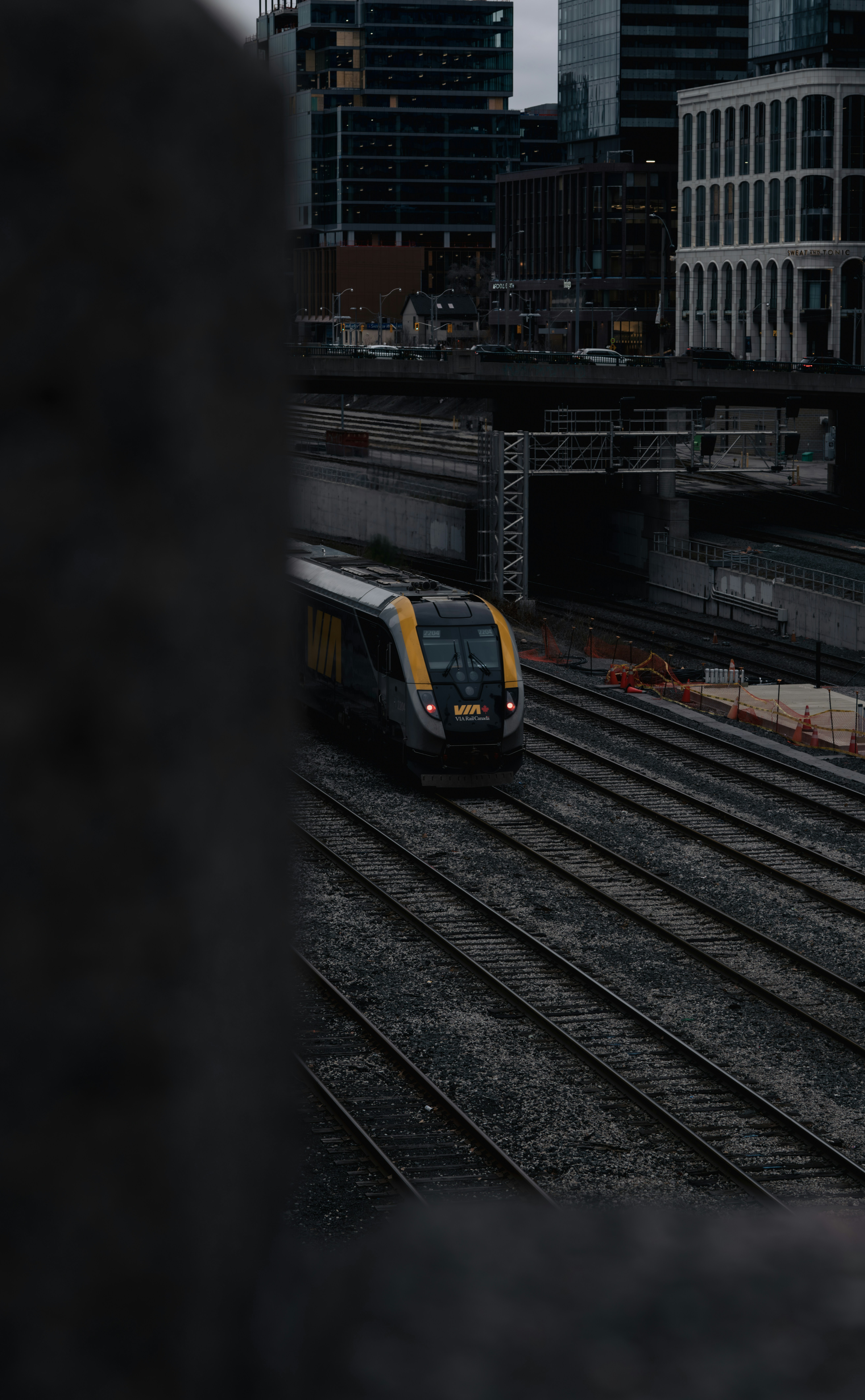 A train traveling down train tracks next to tall buildings photo – Free ...