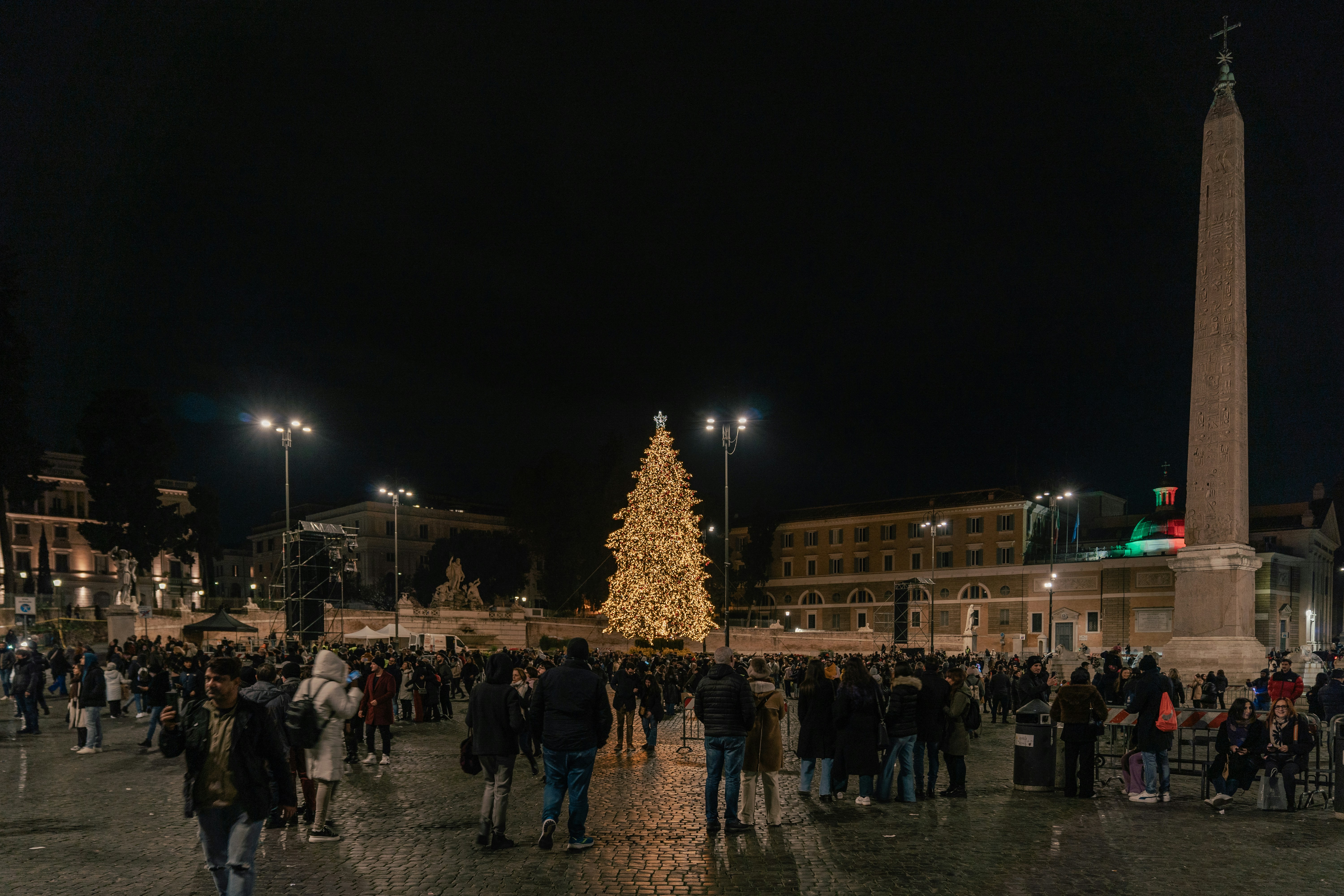 A large group of people standing around a christmas tree photo – Free ...