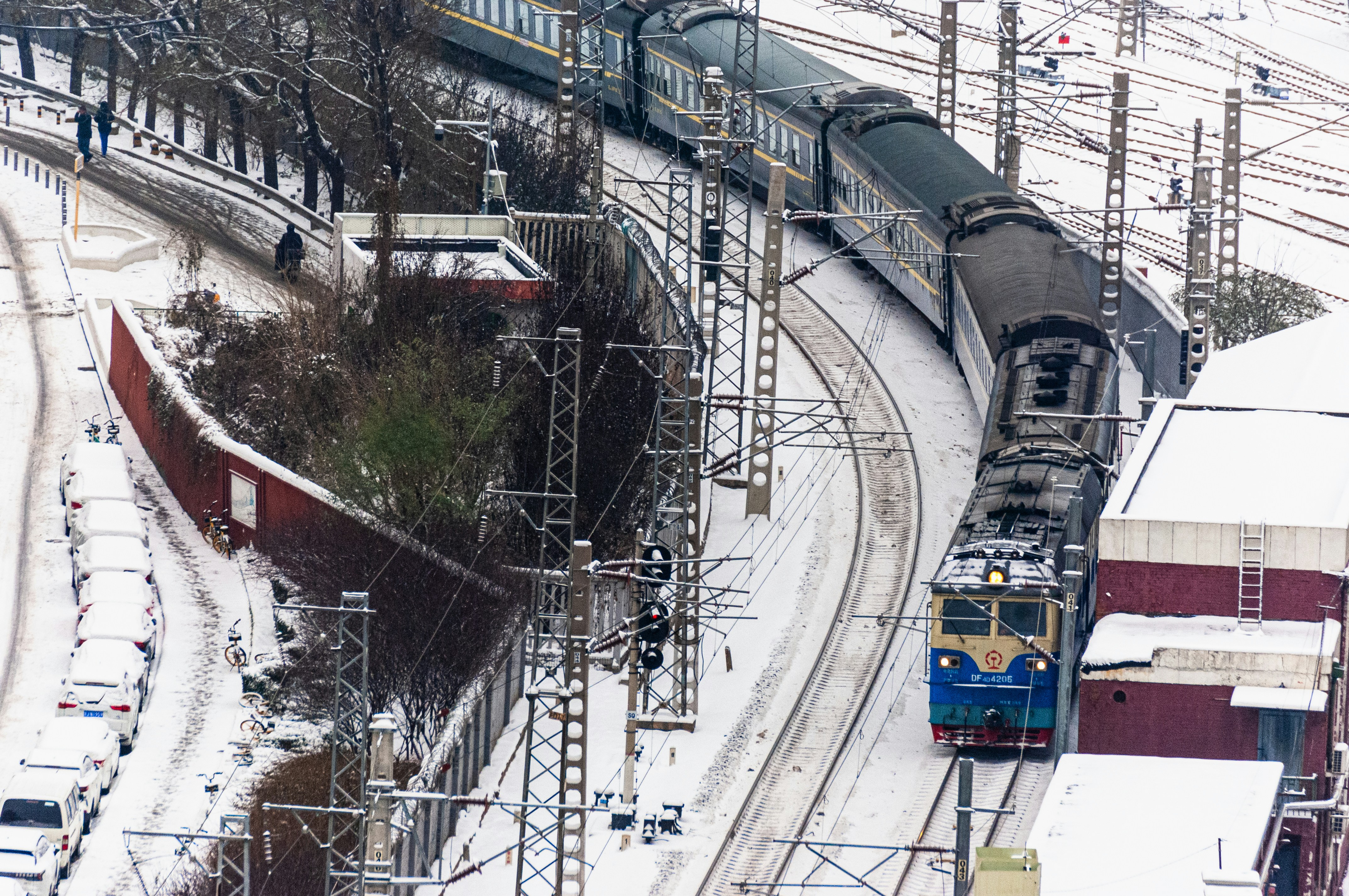 A train traveling down tracks next to a snow covered hillside photo ...
