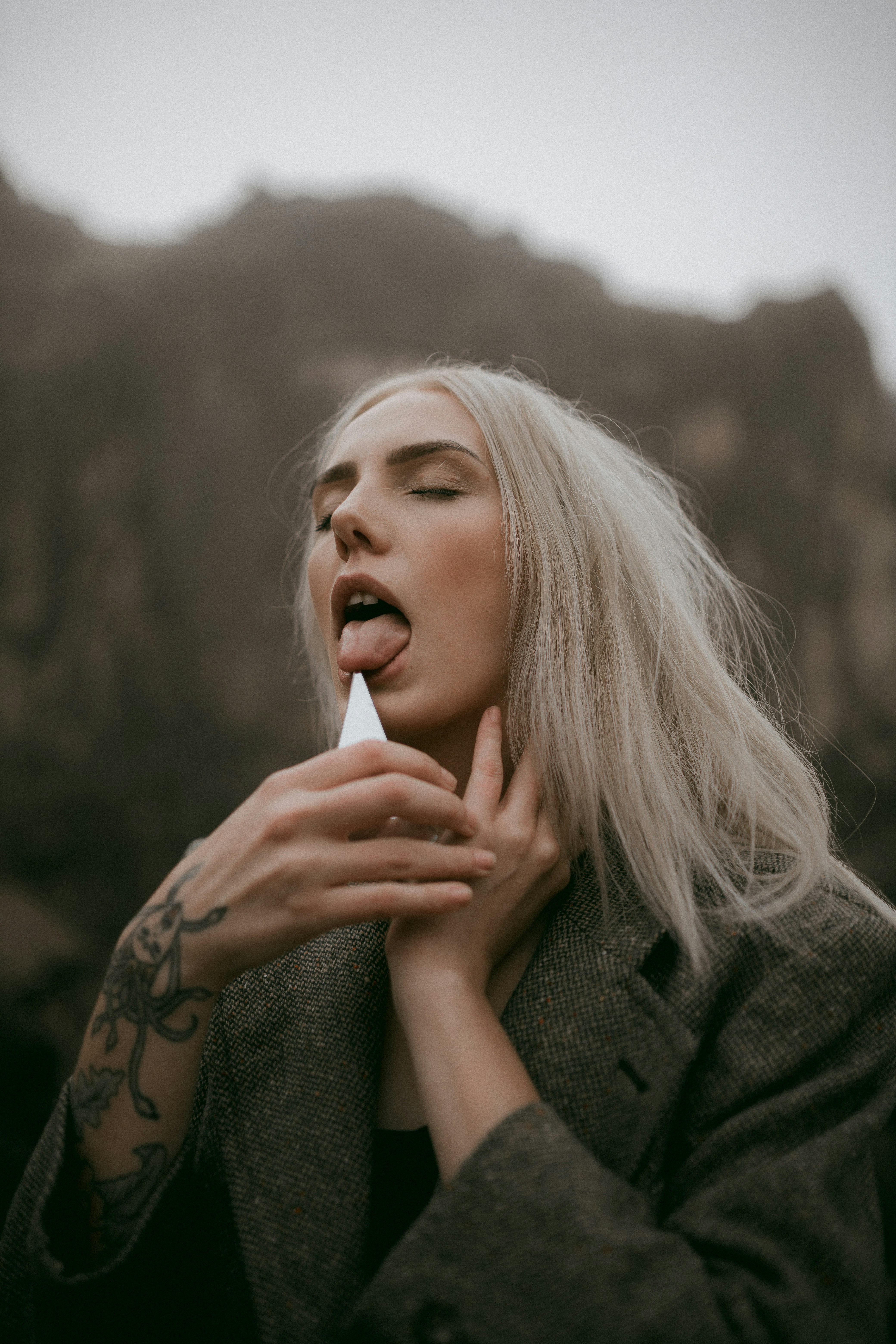 Tongue and Stone: A moody portrait against a rugged, misty backdrop
