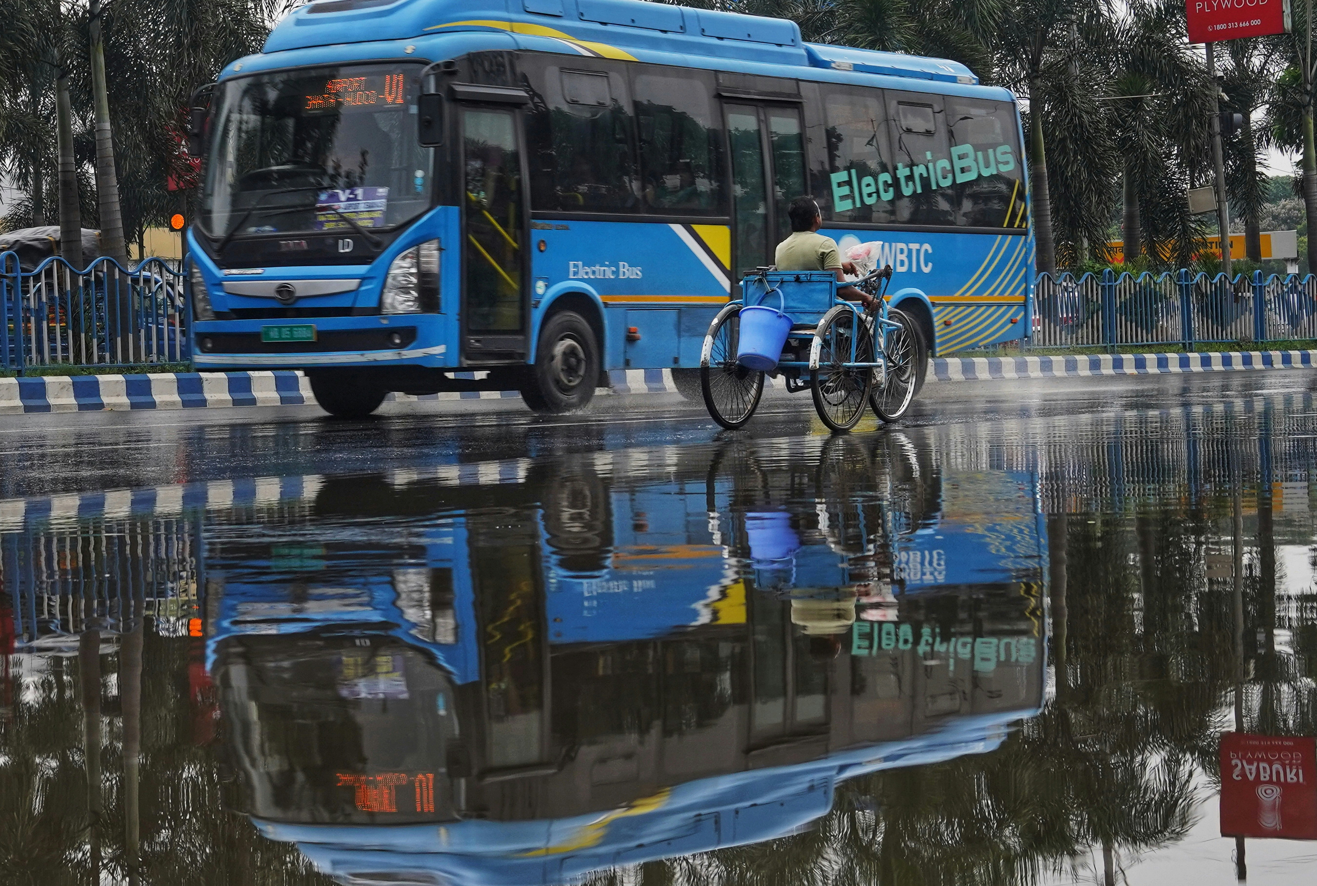 A blue bus driving down a rain soaked street photo – Free Wallpaper ...