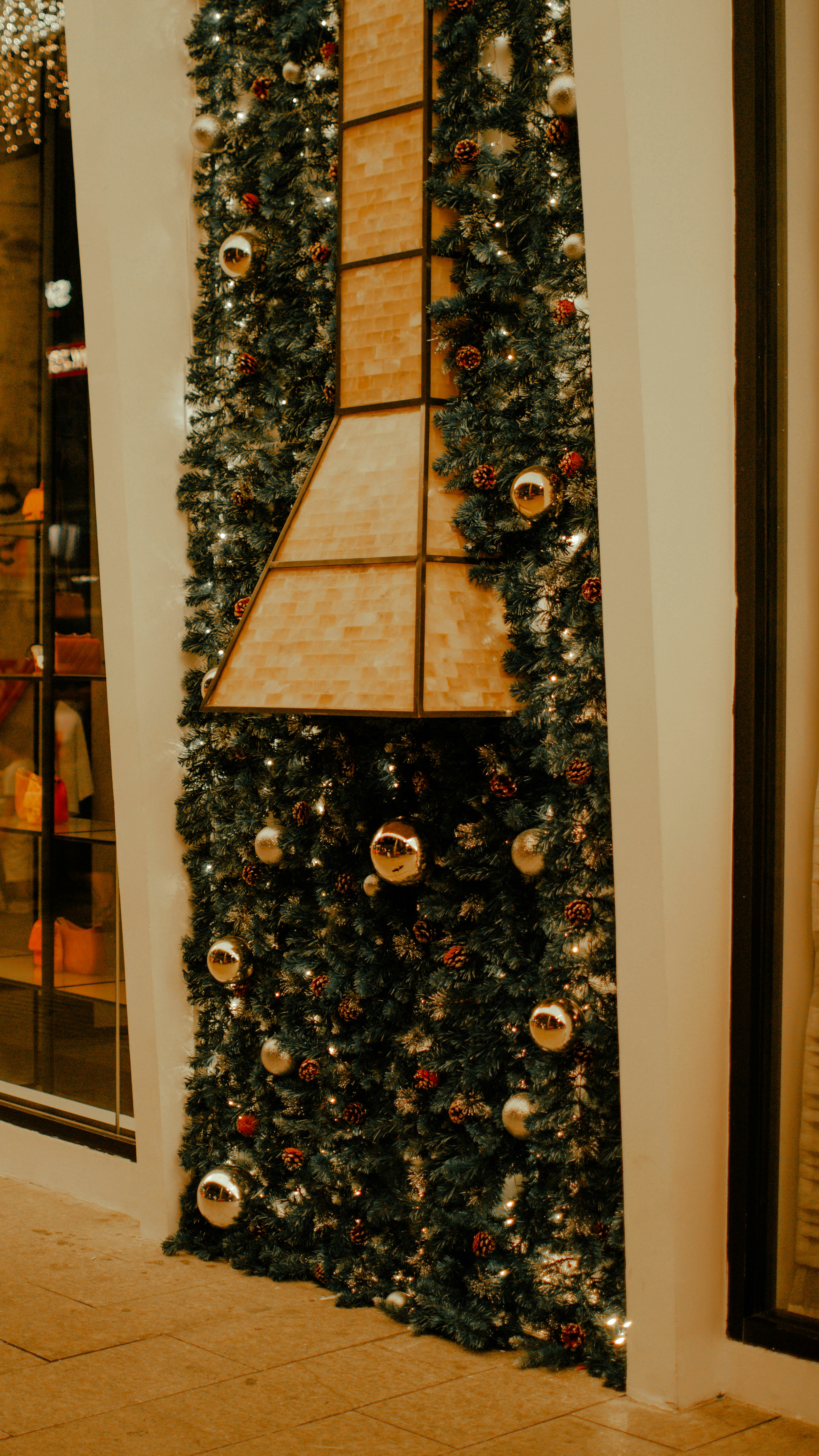 Vertical Garland of Gleaming Ornaments Framing a Warm Storefront Glow
