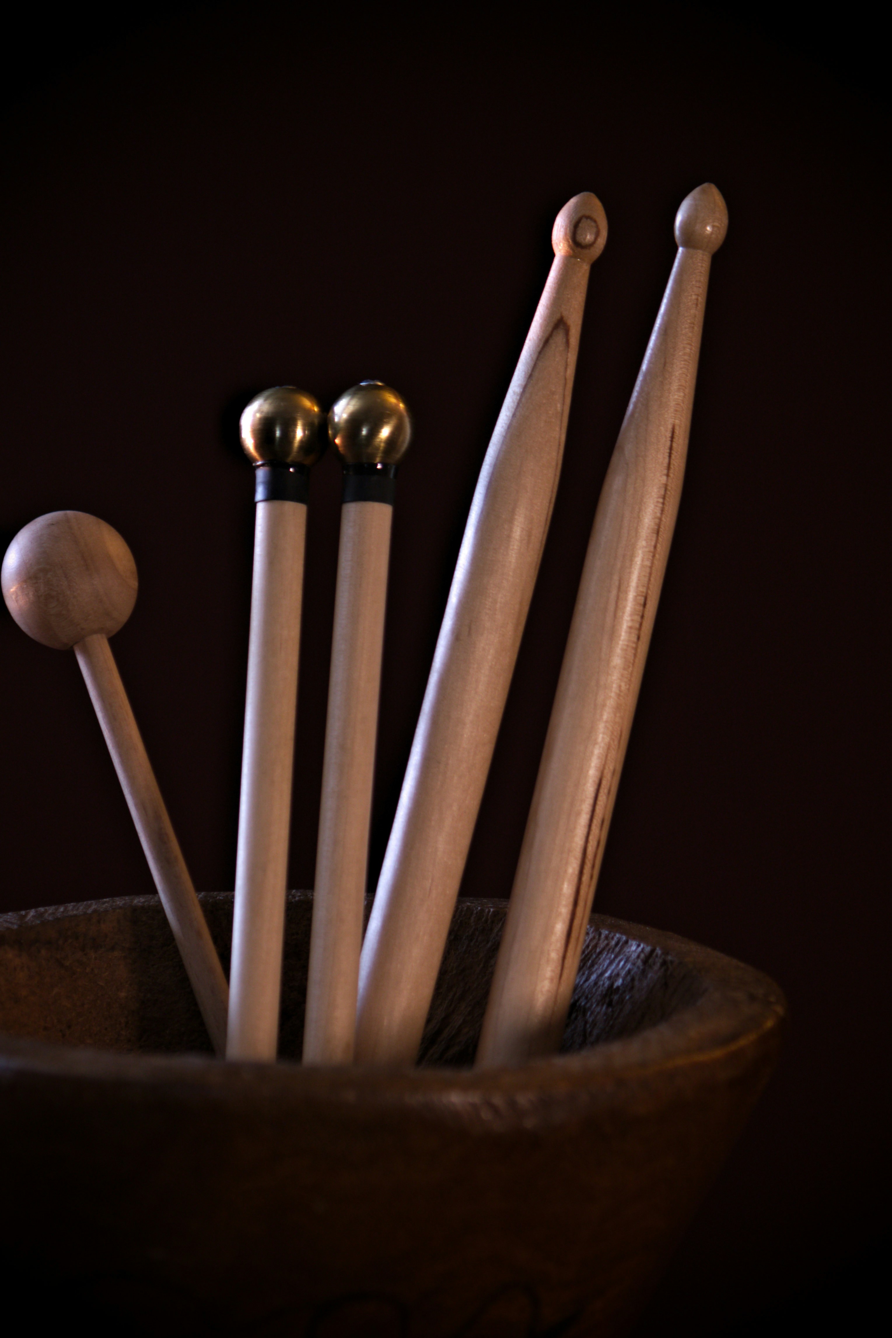 Five Silent Drumsticks Resting in a Weathered Clay Cup