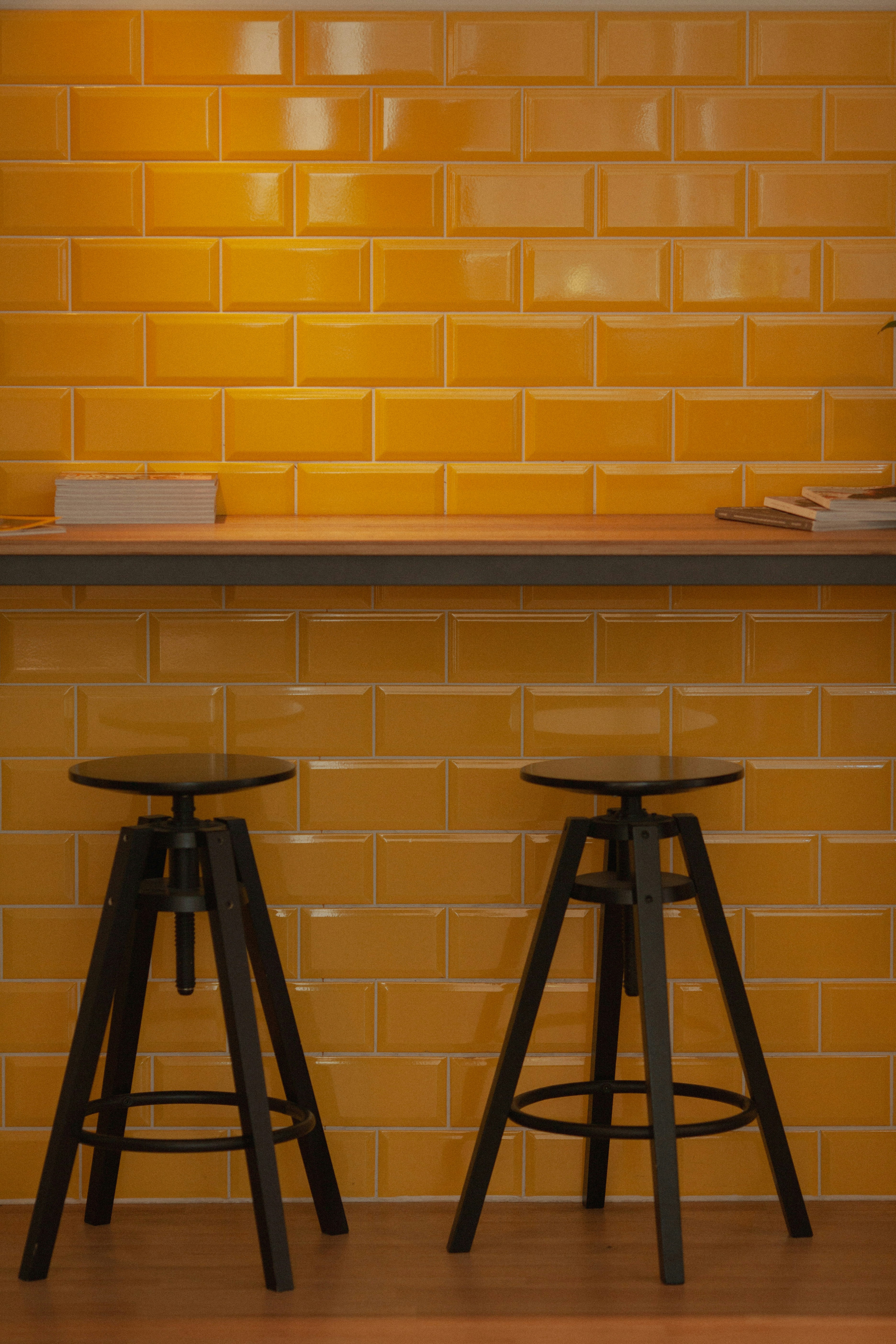 Amber Tile Wall and Twin Bar Stools: Quiet Geometry in a Café Nook