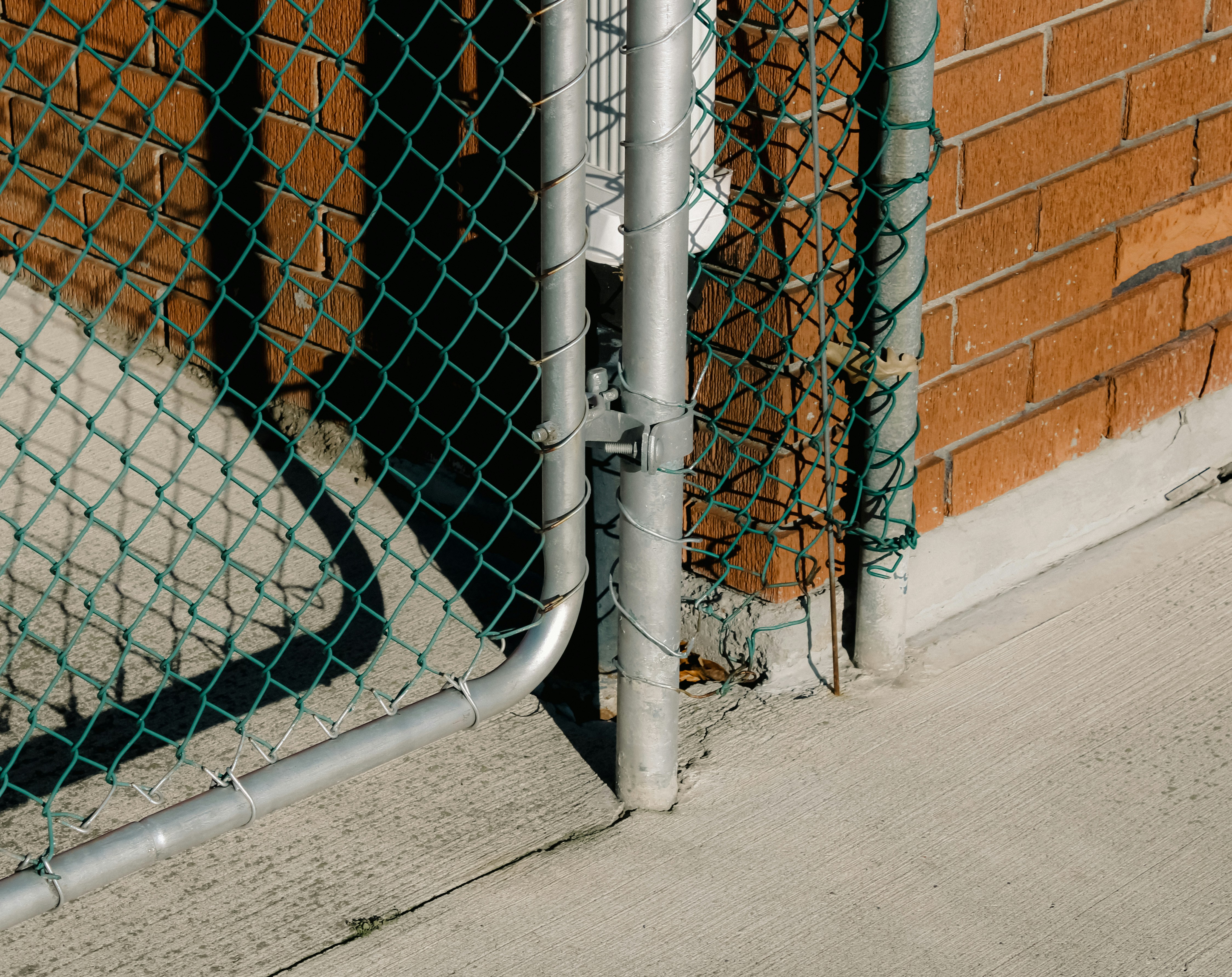 A white fire hydrant sitting next to a chain link fence photo – Free ...