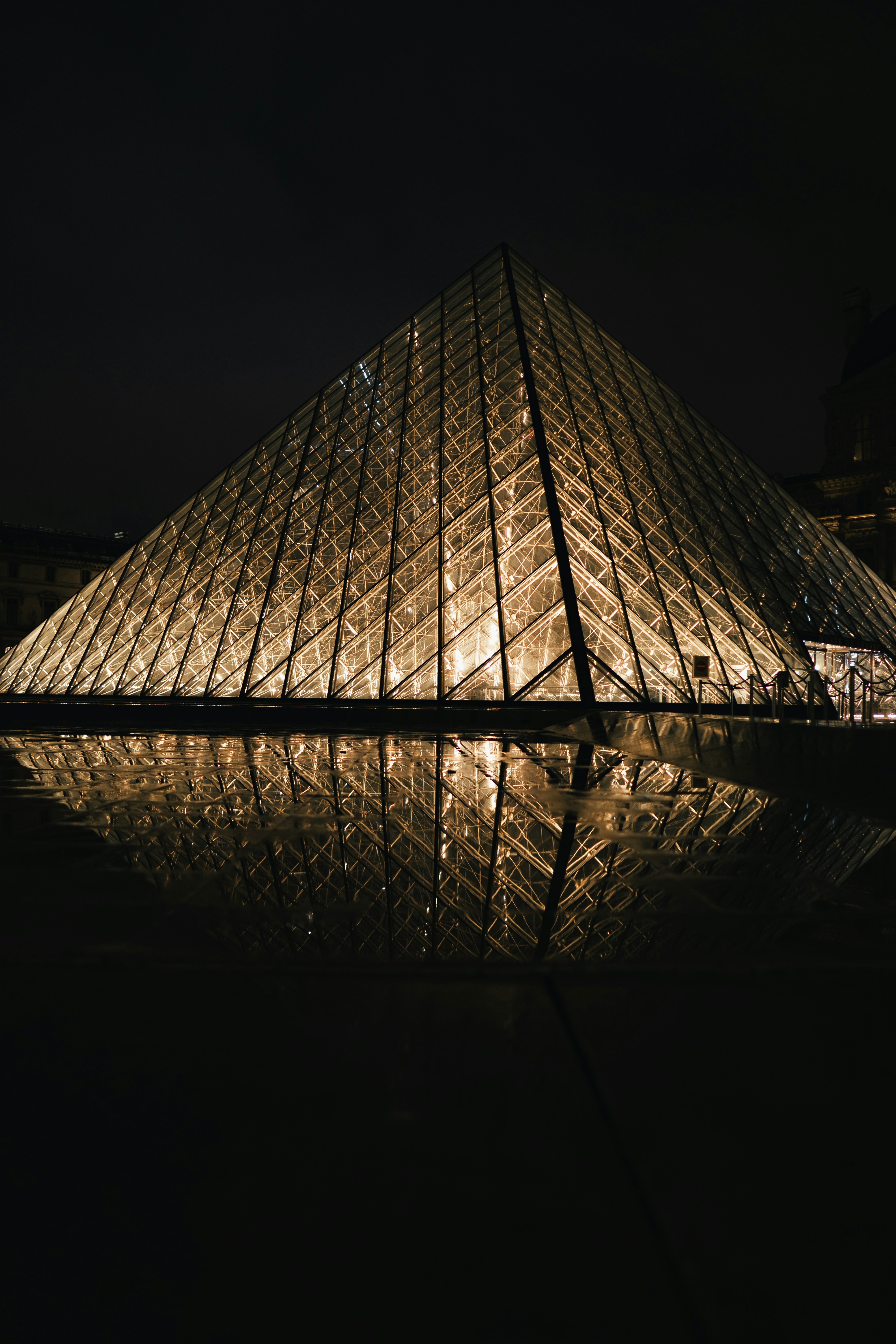 A large glass pyramid lit up at night photo – Free Louvre pyramid Image ...
