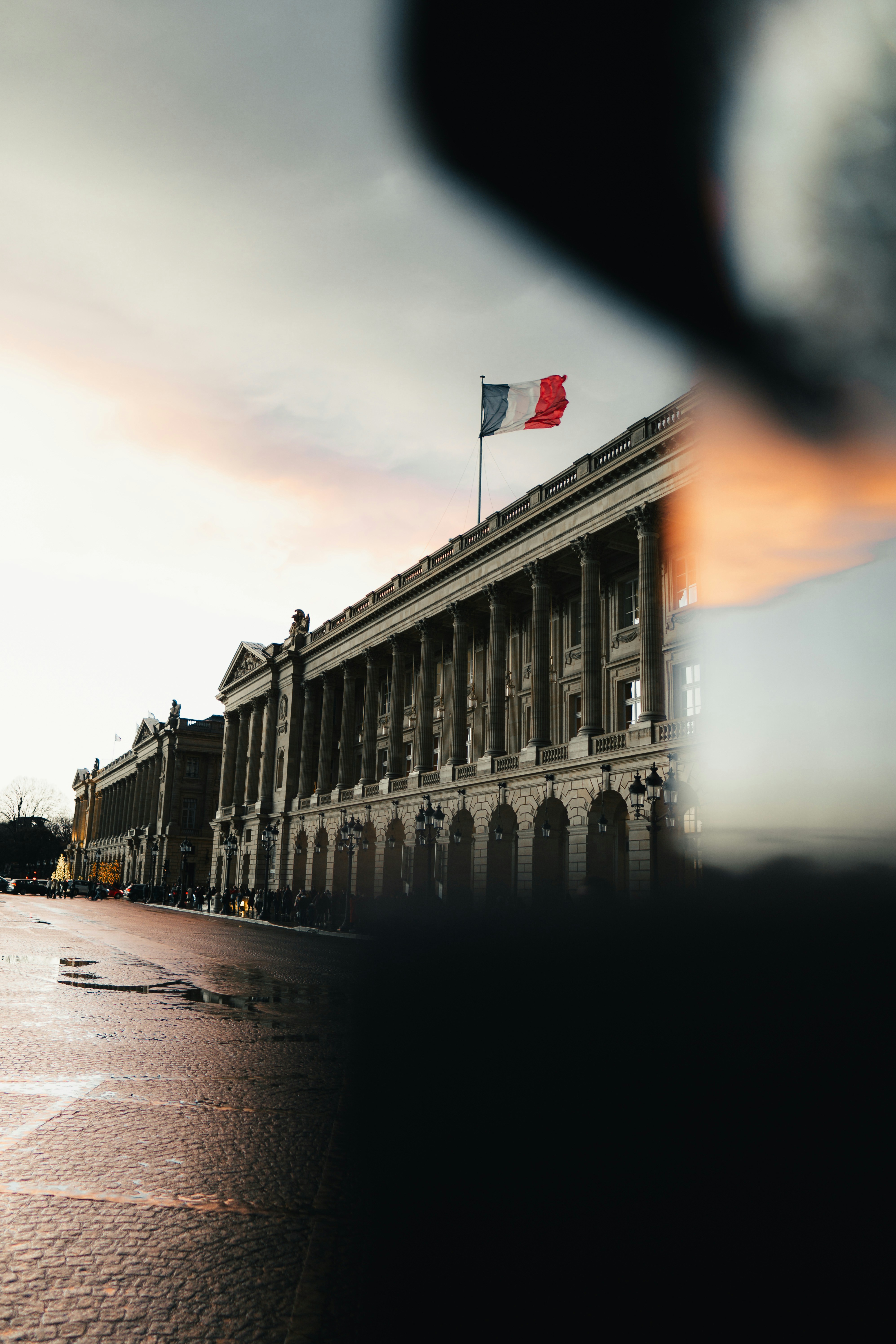 Dusk Over a Parisian Colonnade Crowned by the French Flag