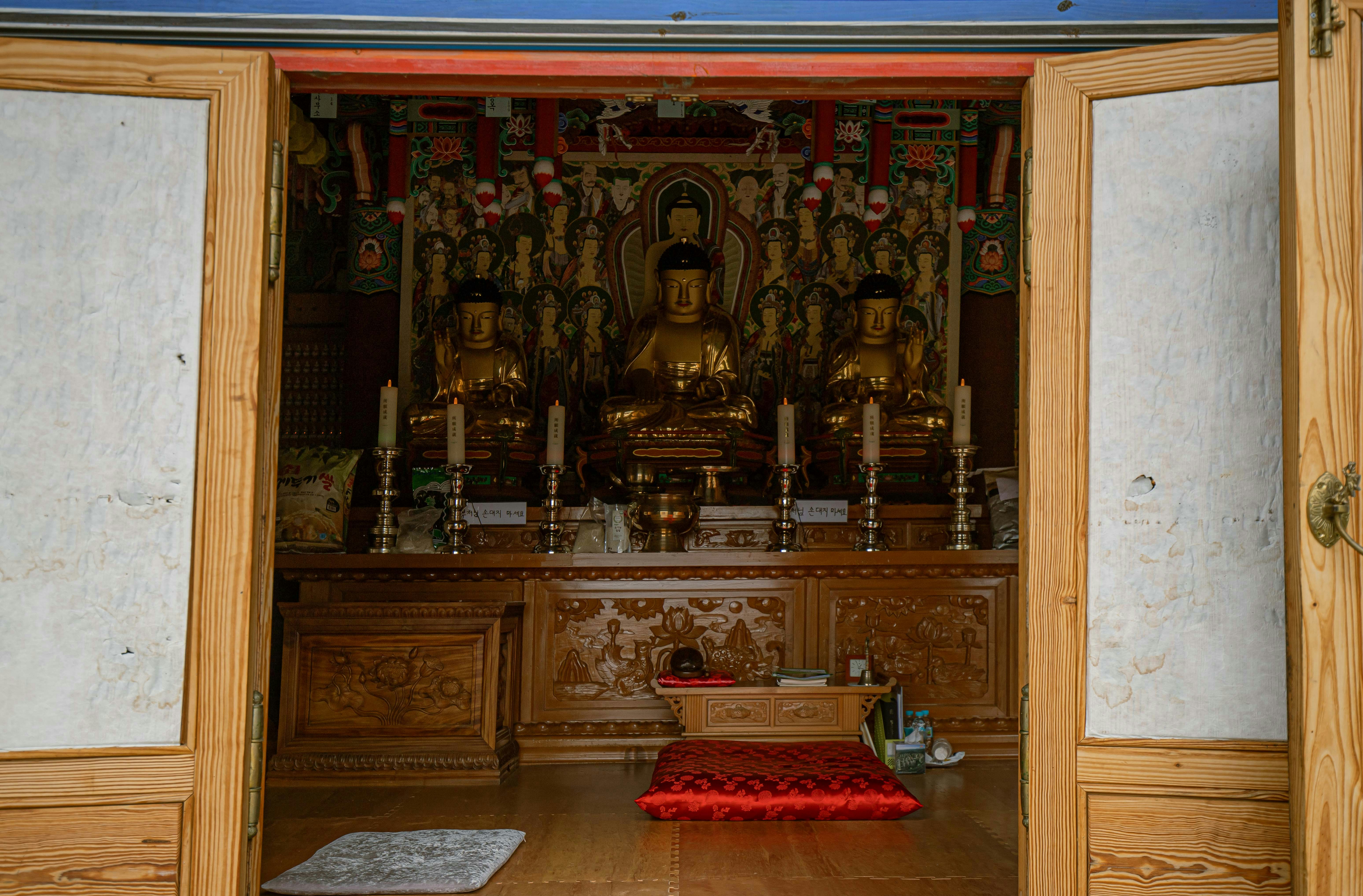 Gilded Silence: The Central Buddha Shrine Framed by Carved Temple Doors