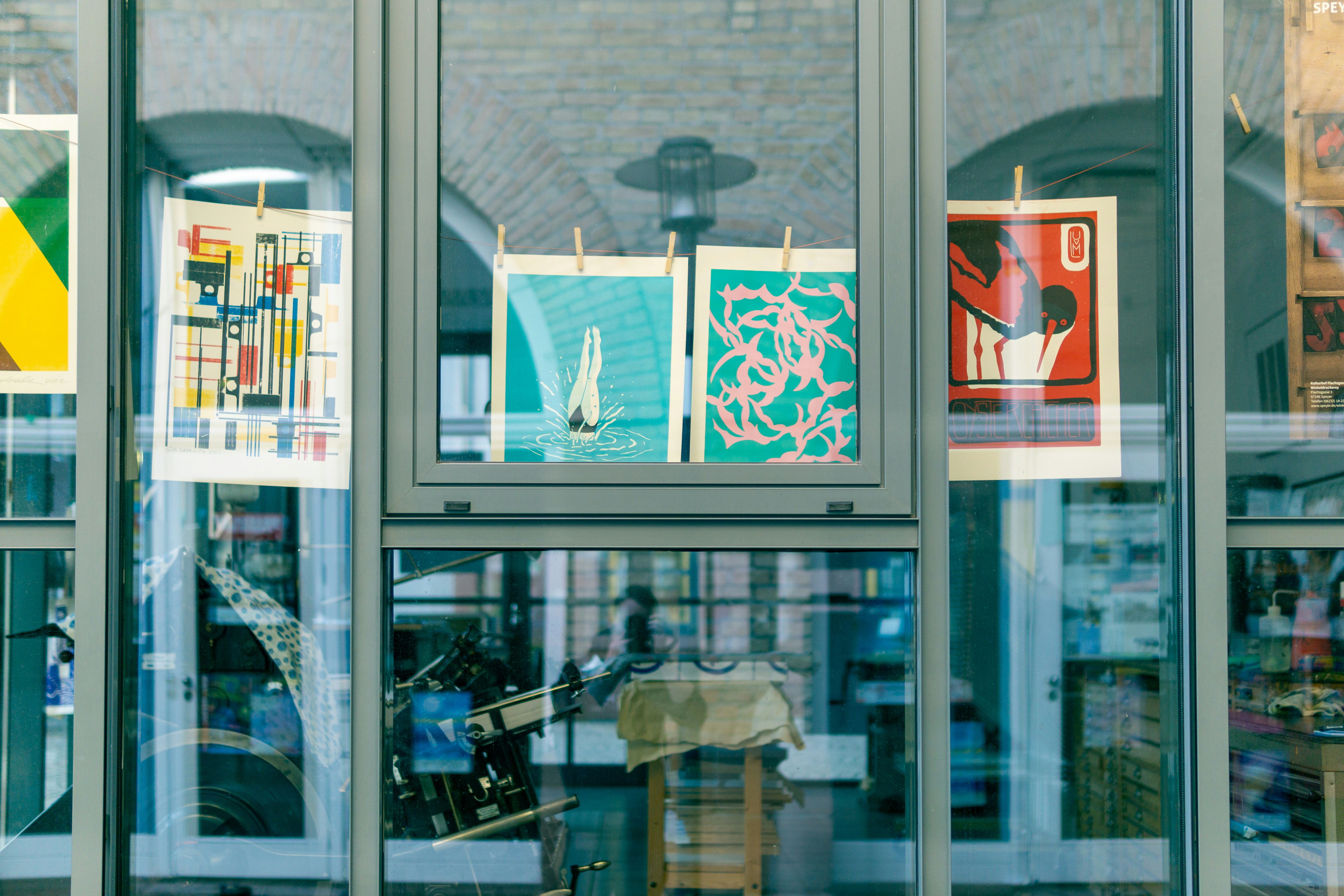 A store front with posters on the glass photo – Free Kunst Image on ...