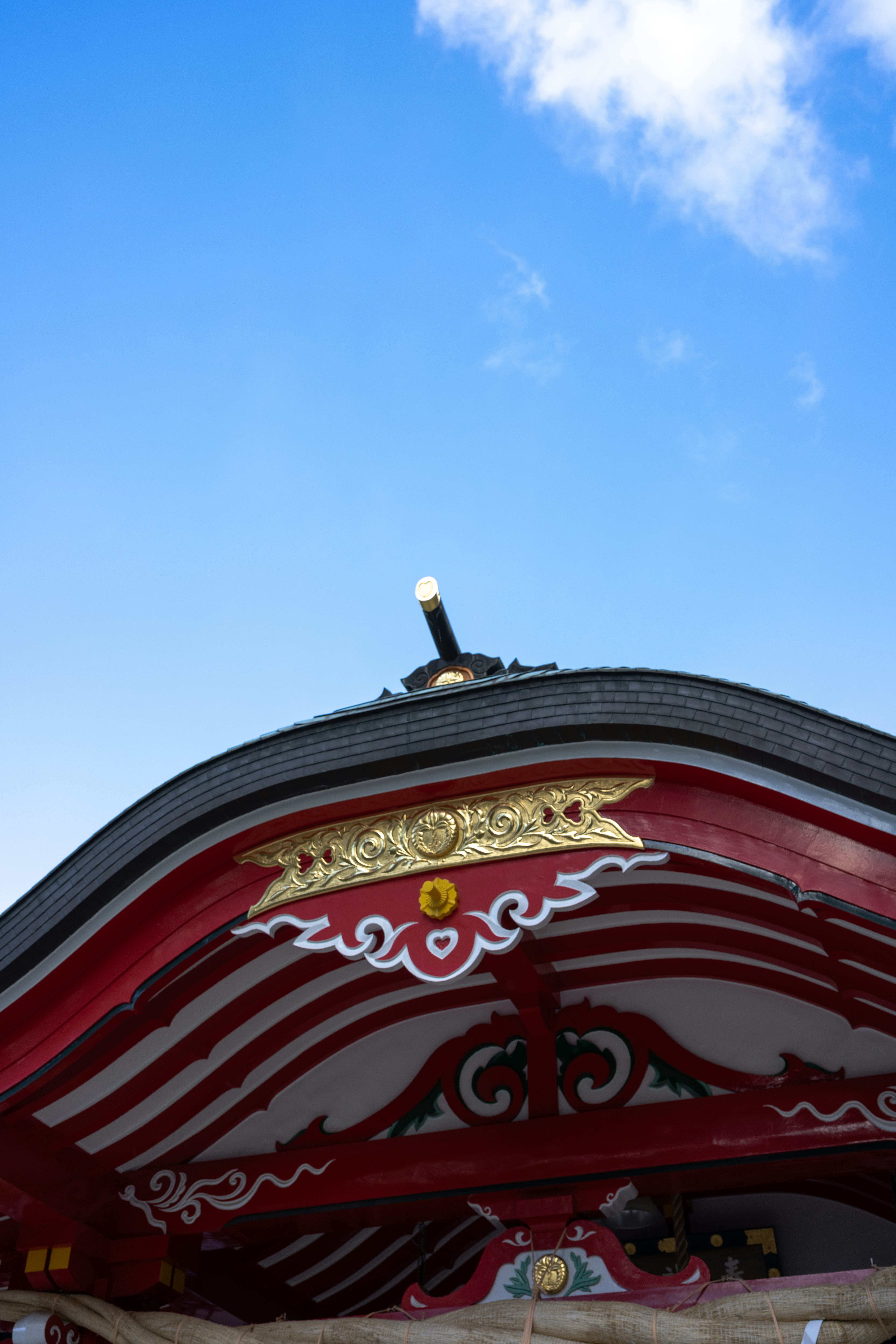 Gold Filigree on a Red Temple Roof Reaching Toward a Clear Blue Sky