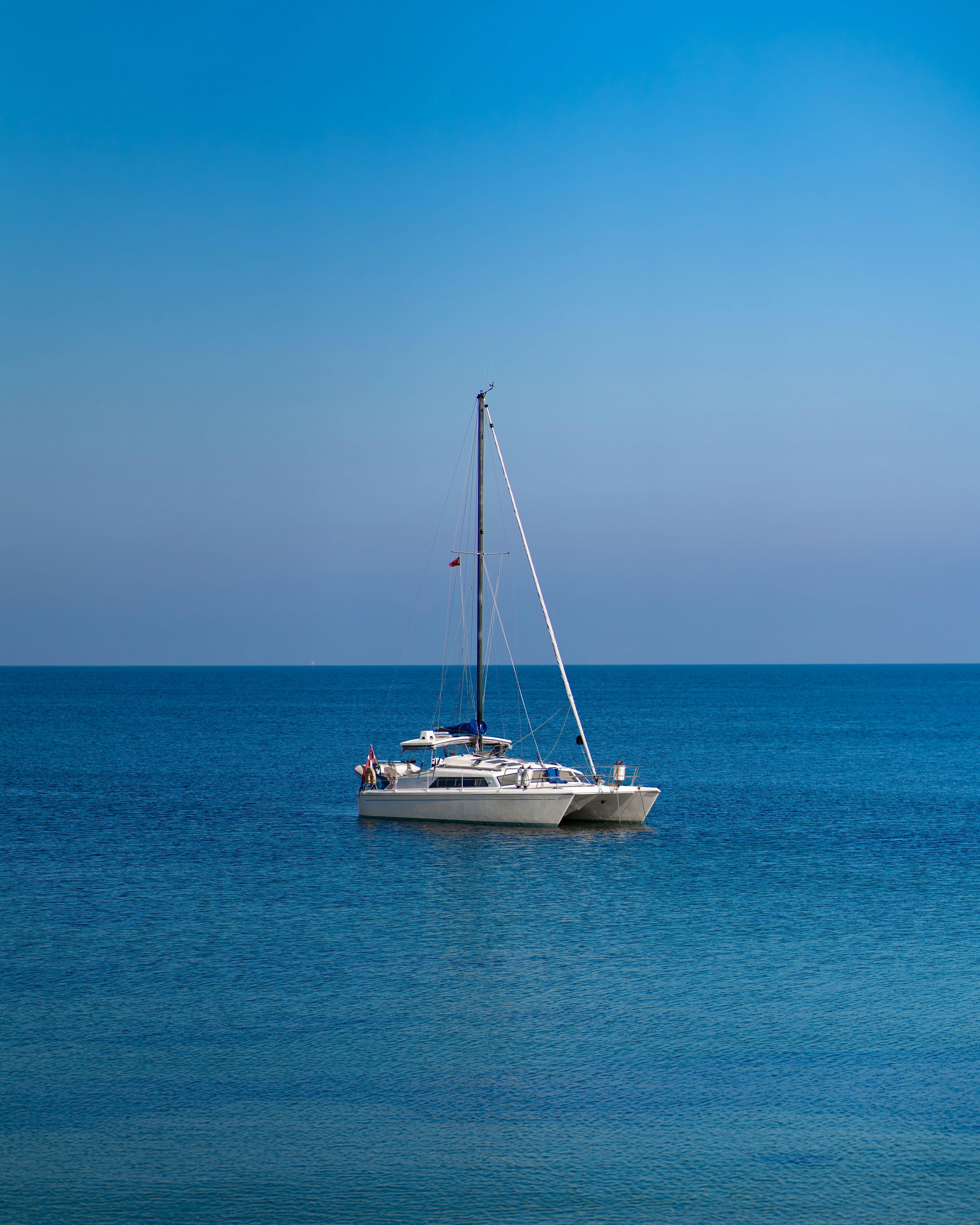 Foto zum Thema Ein Segelboot, das mitten auf dem Ozean schwimmt ...