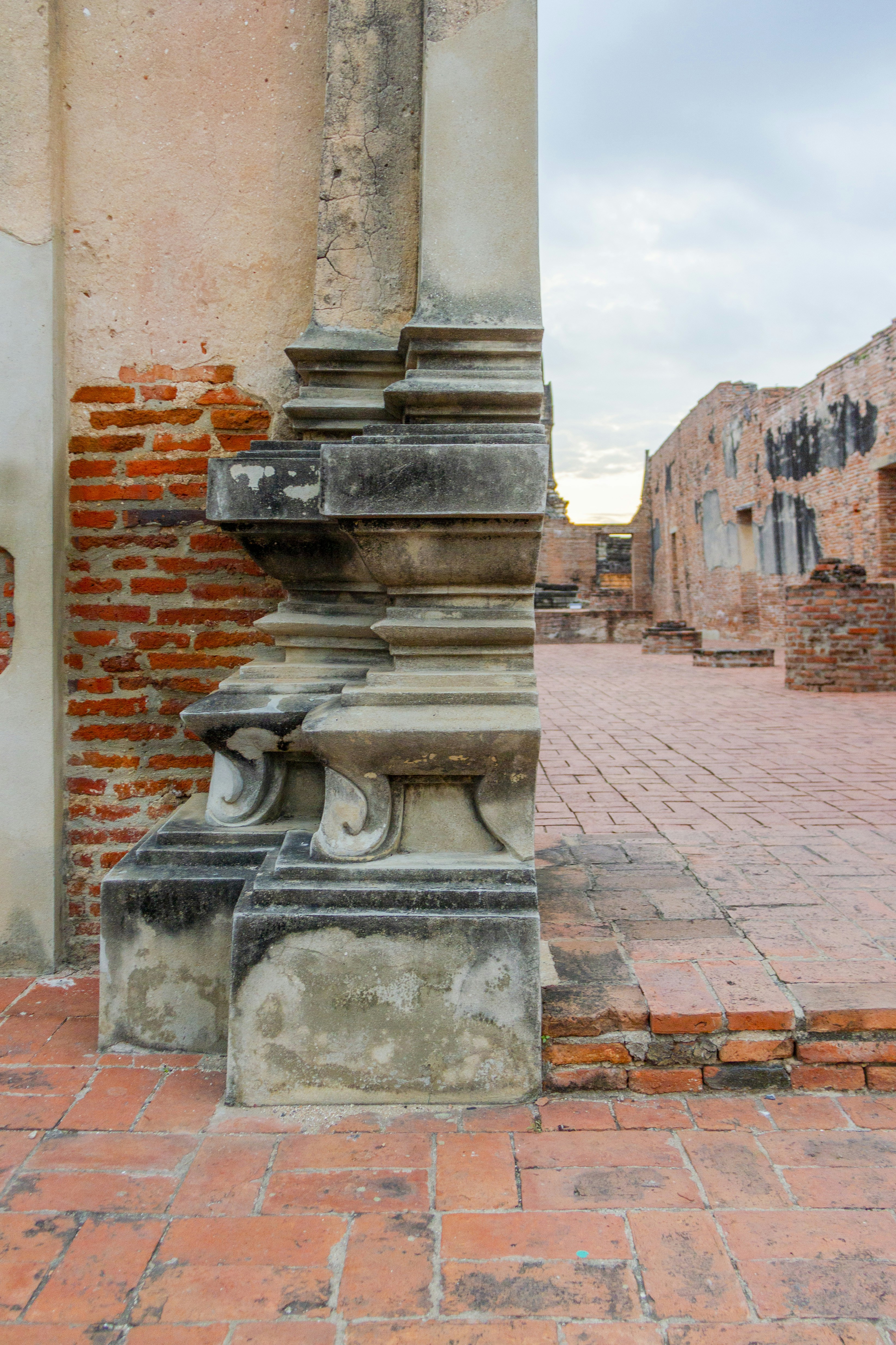 Weathered Pillar at the Threshold of a Brick-Ruin Corridor
