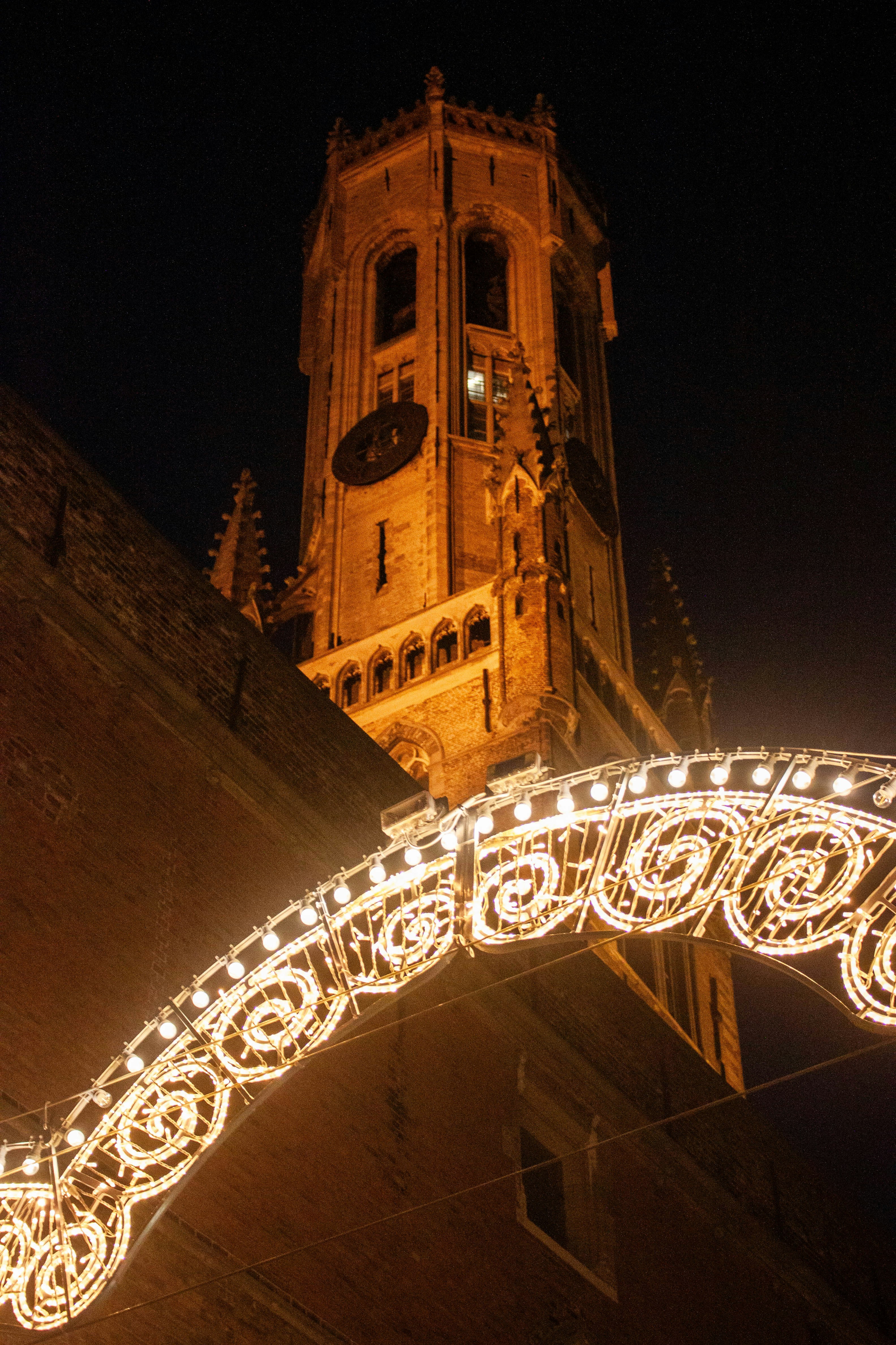 Gothic Bell Tower Bathed in Nightfall: Illuminated Archway Frames the Tower