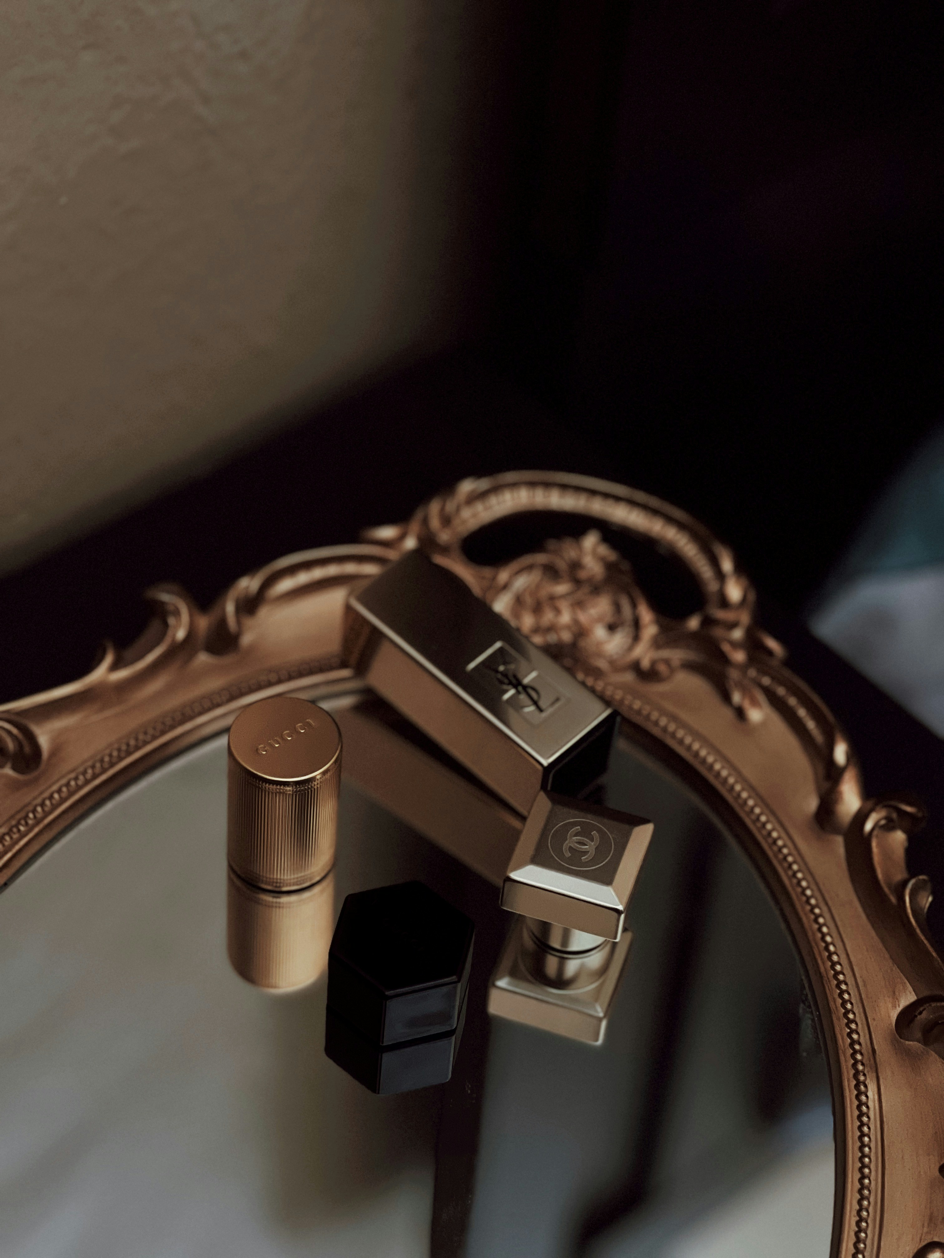 A collection of elegant perfume bottles arranged on an ornate mirror, showcasing their intricate designs and reflections.