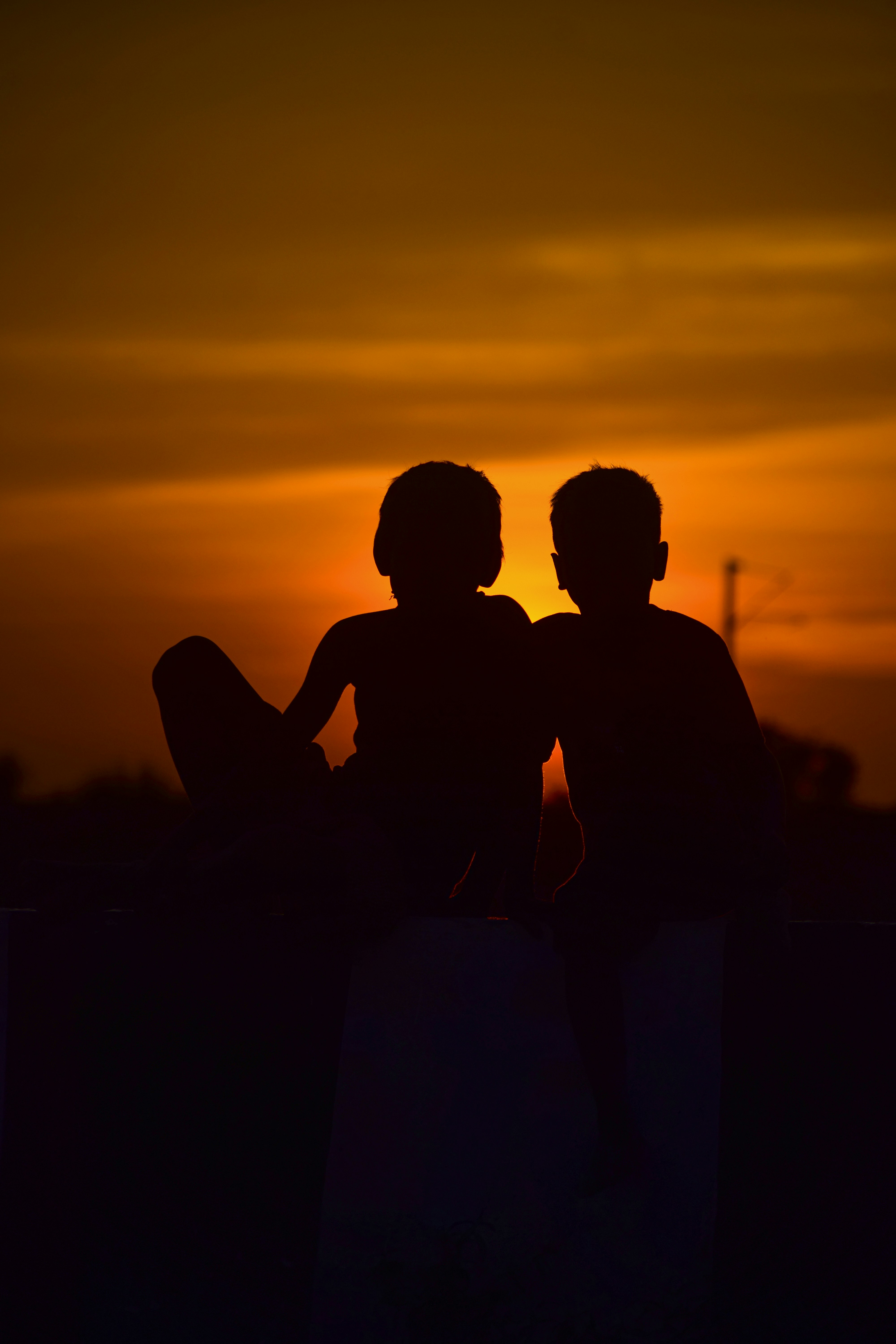 A couple of people sitting next to each other photo – Free Kachhla ...