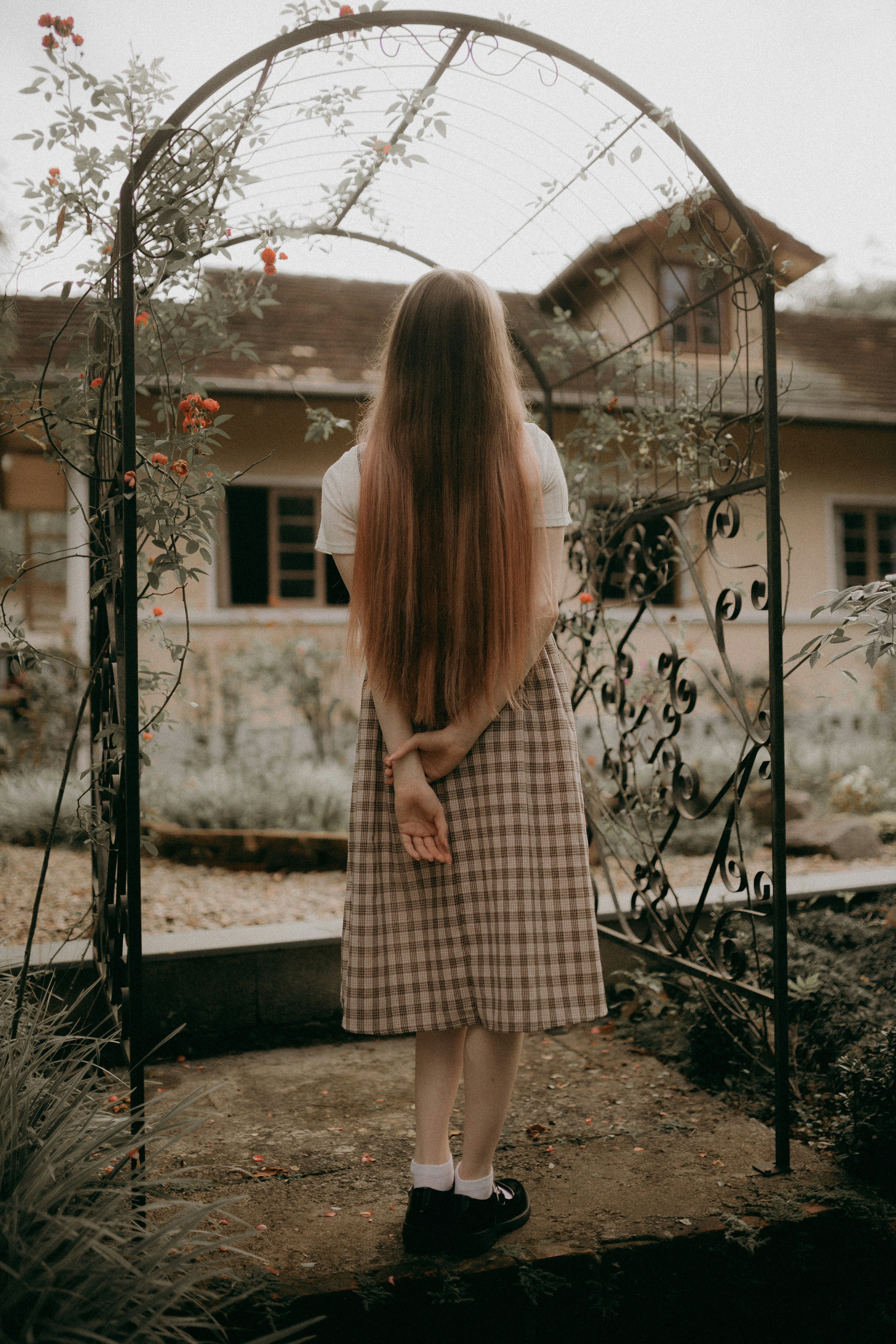 In Quiet Bloom: Portrait Under a Wrought-Iron Arch