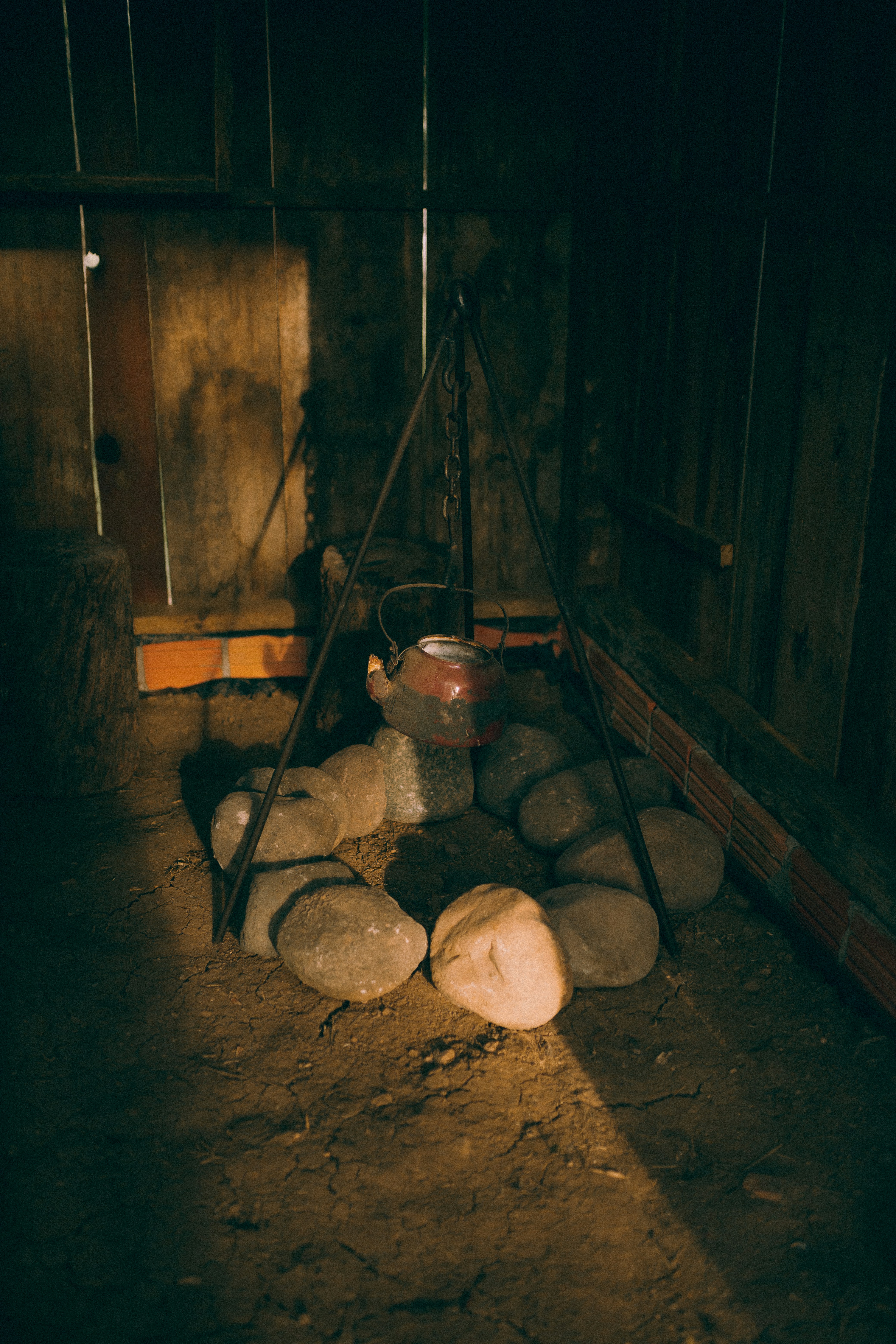Red Kettle on a Tripod: Quiet Hearth in a Weathered Shed
