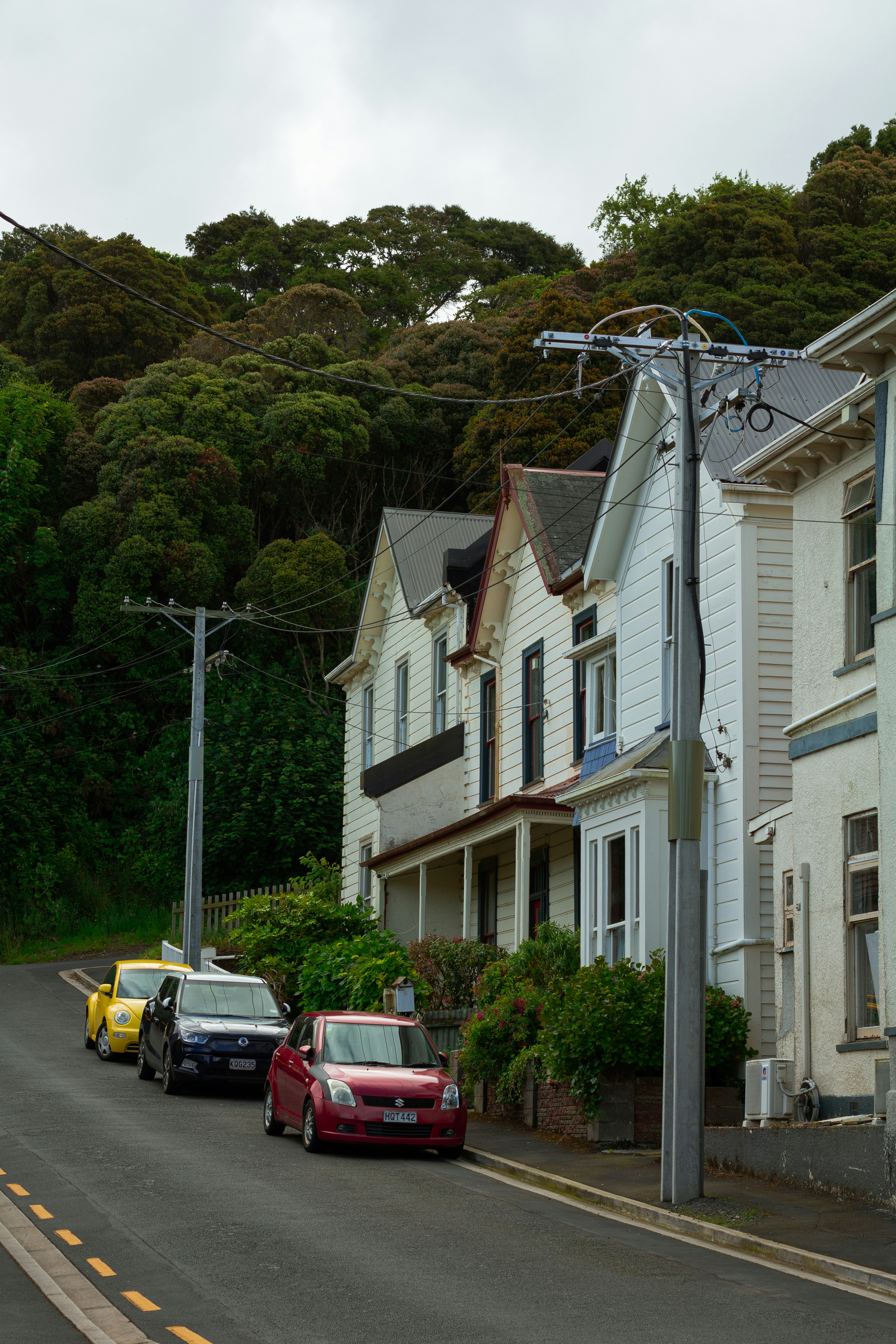 Red Sedan on a Sloped Street Among Painted Victorian Row Houses